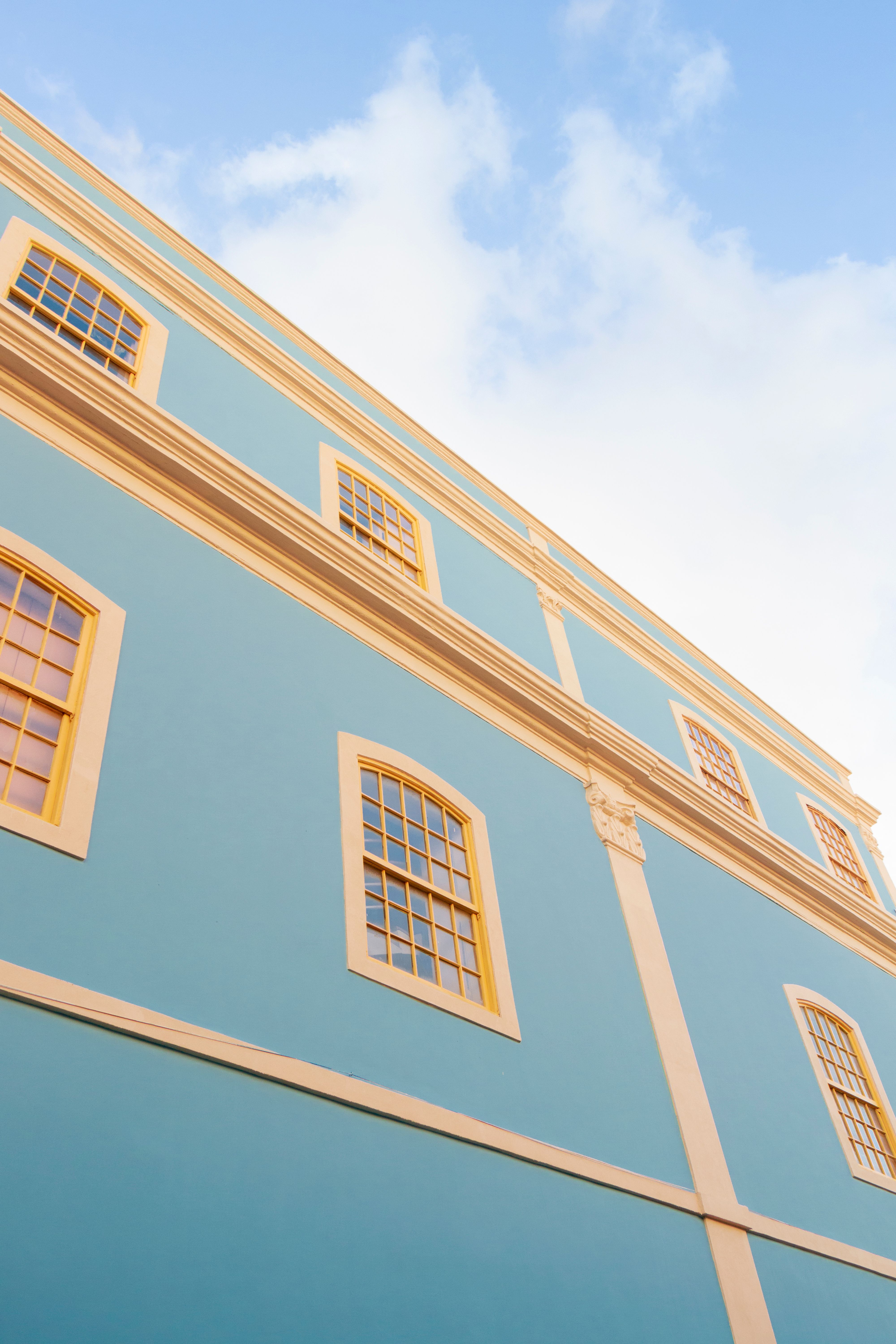 Blue Concrete Building Under Cloudy Sky · Free Stock Photo