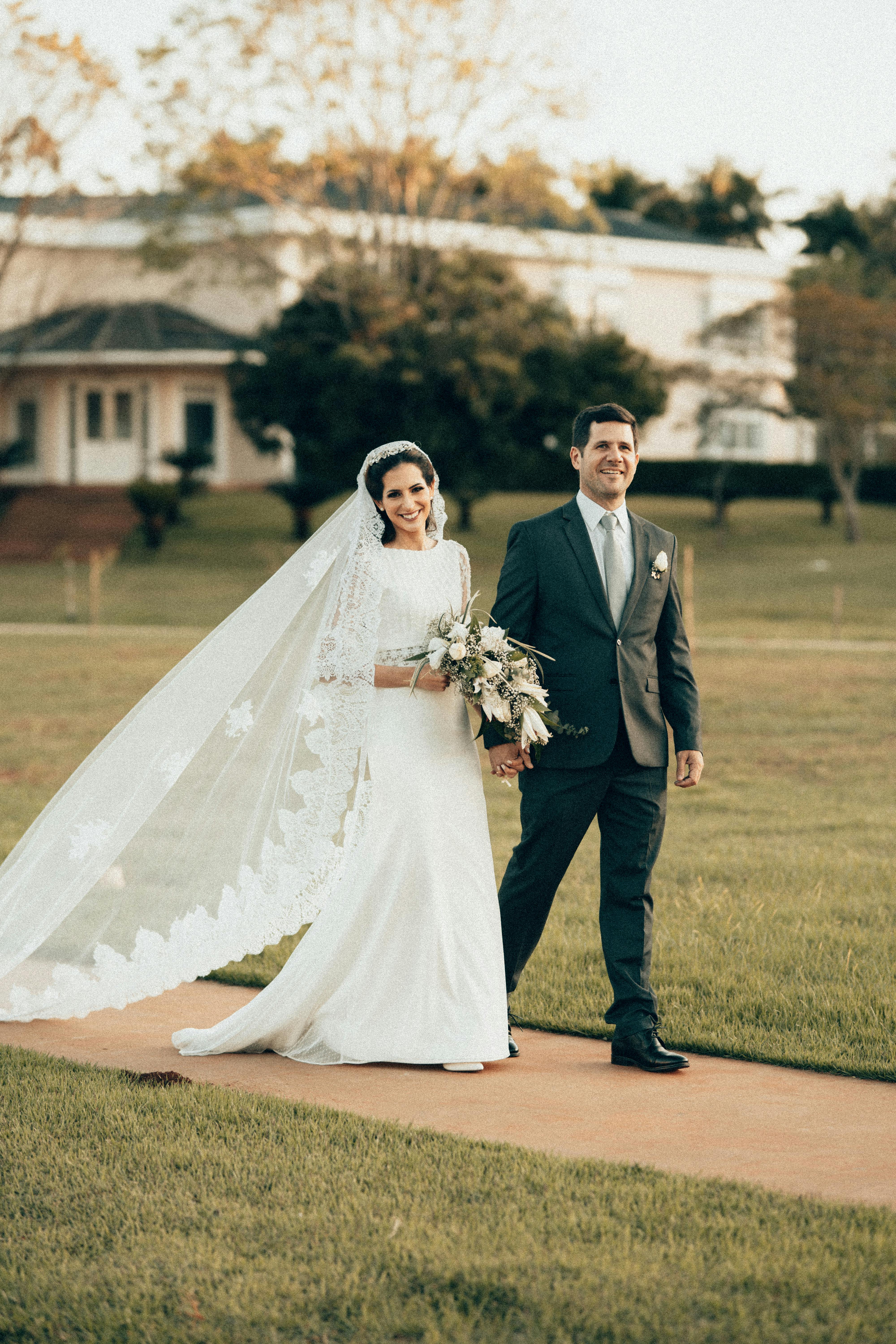Smiling Bride and Groom Walking Alley Outdoors · Free Stock Photo