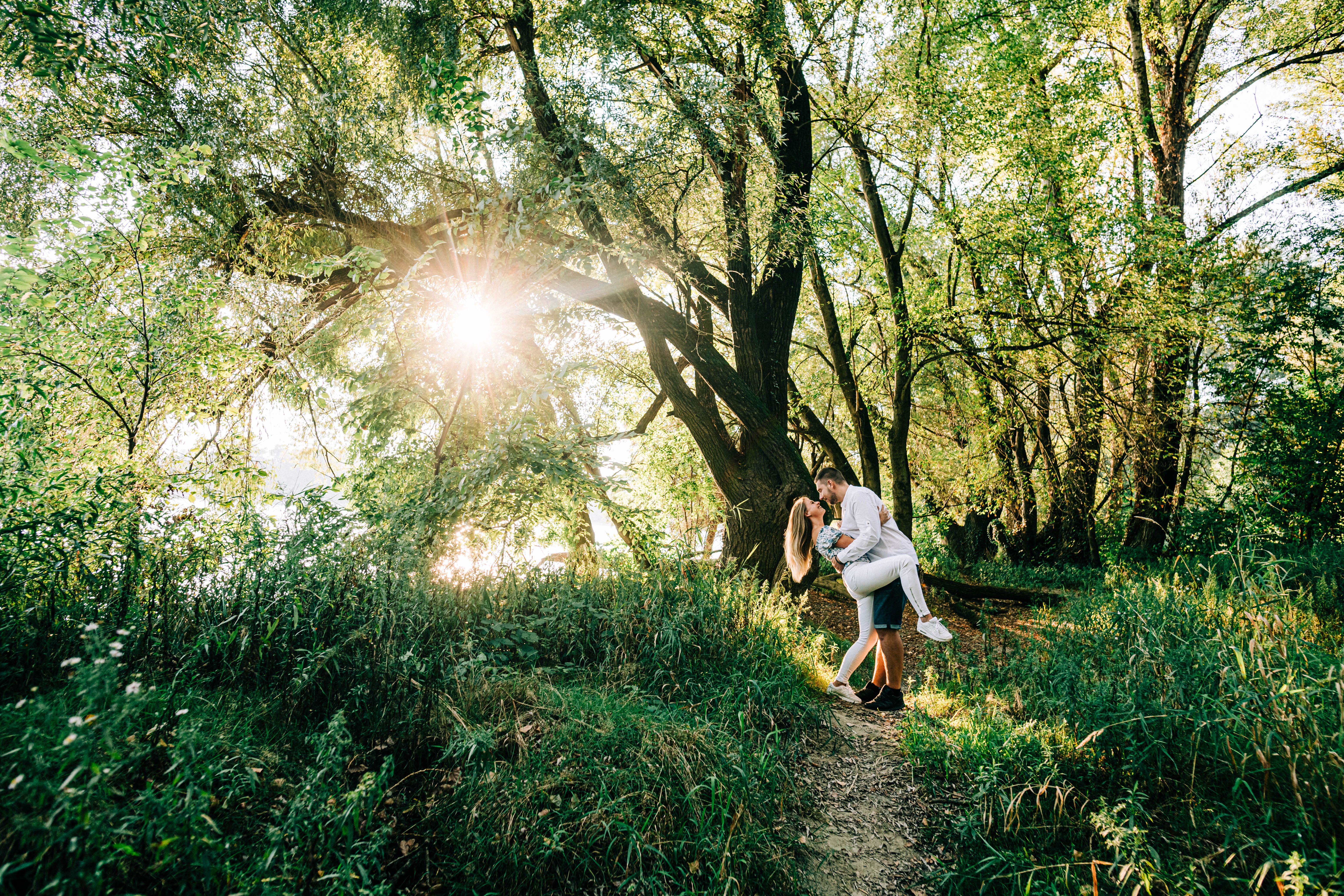 A Couple Standing Together Near the Green Trees · Free Stock Photo