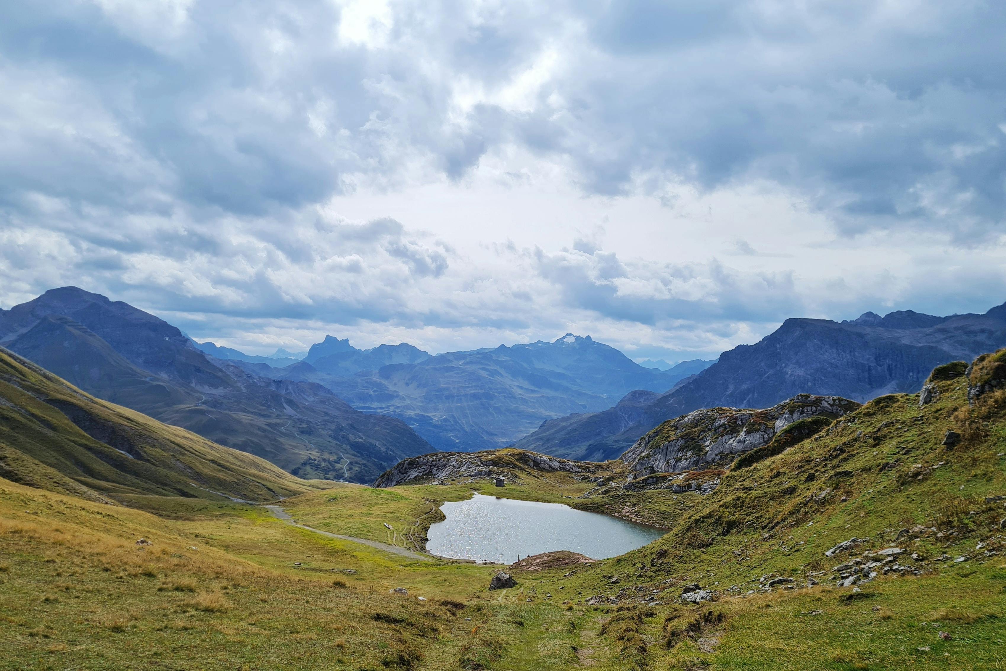 A Lake Between Mountains Under the Cloudy Sky · Free Stock Photo