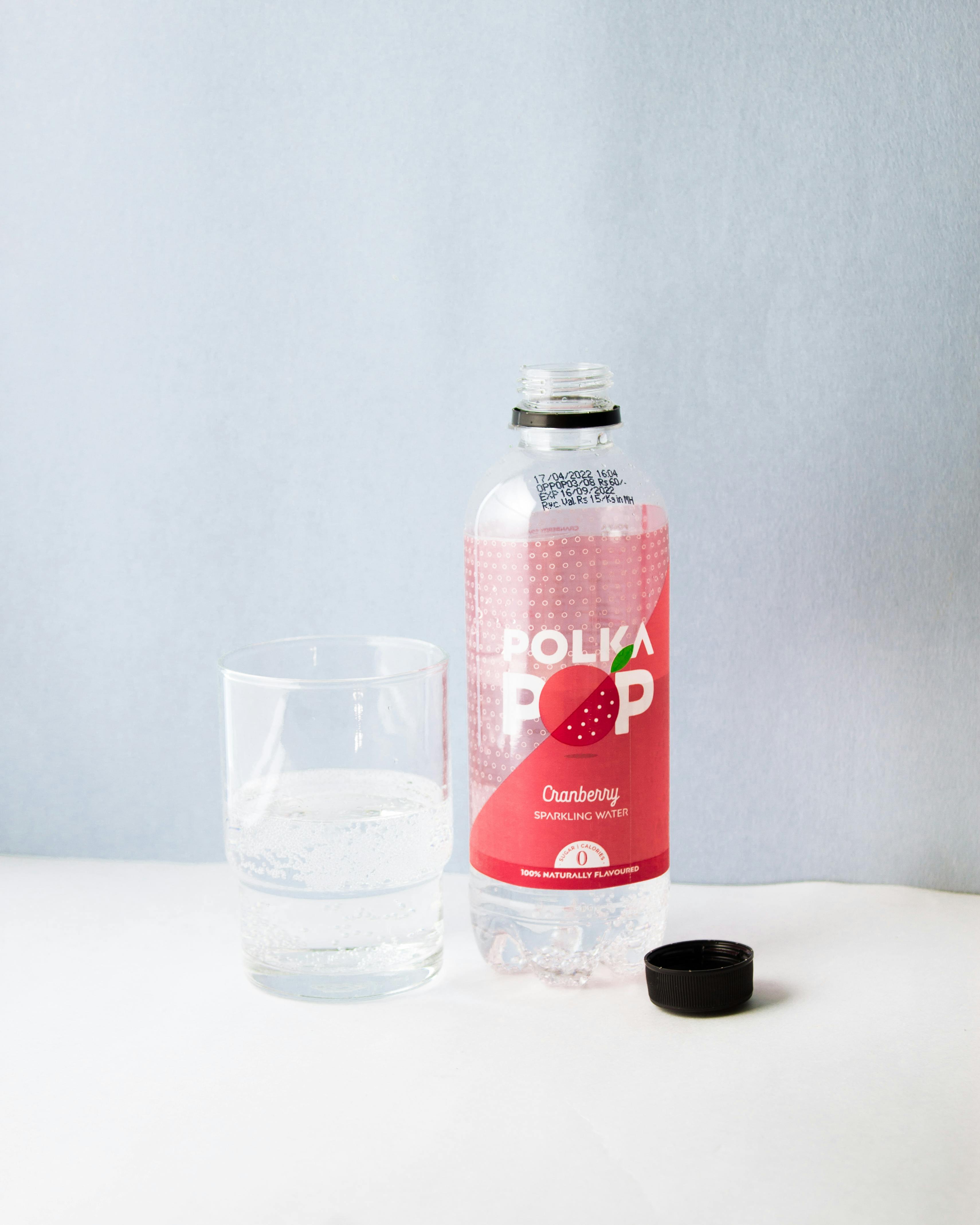 A Glass beside a Bottle of Polka Pop Sparkling Water · Free Stock Photo