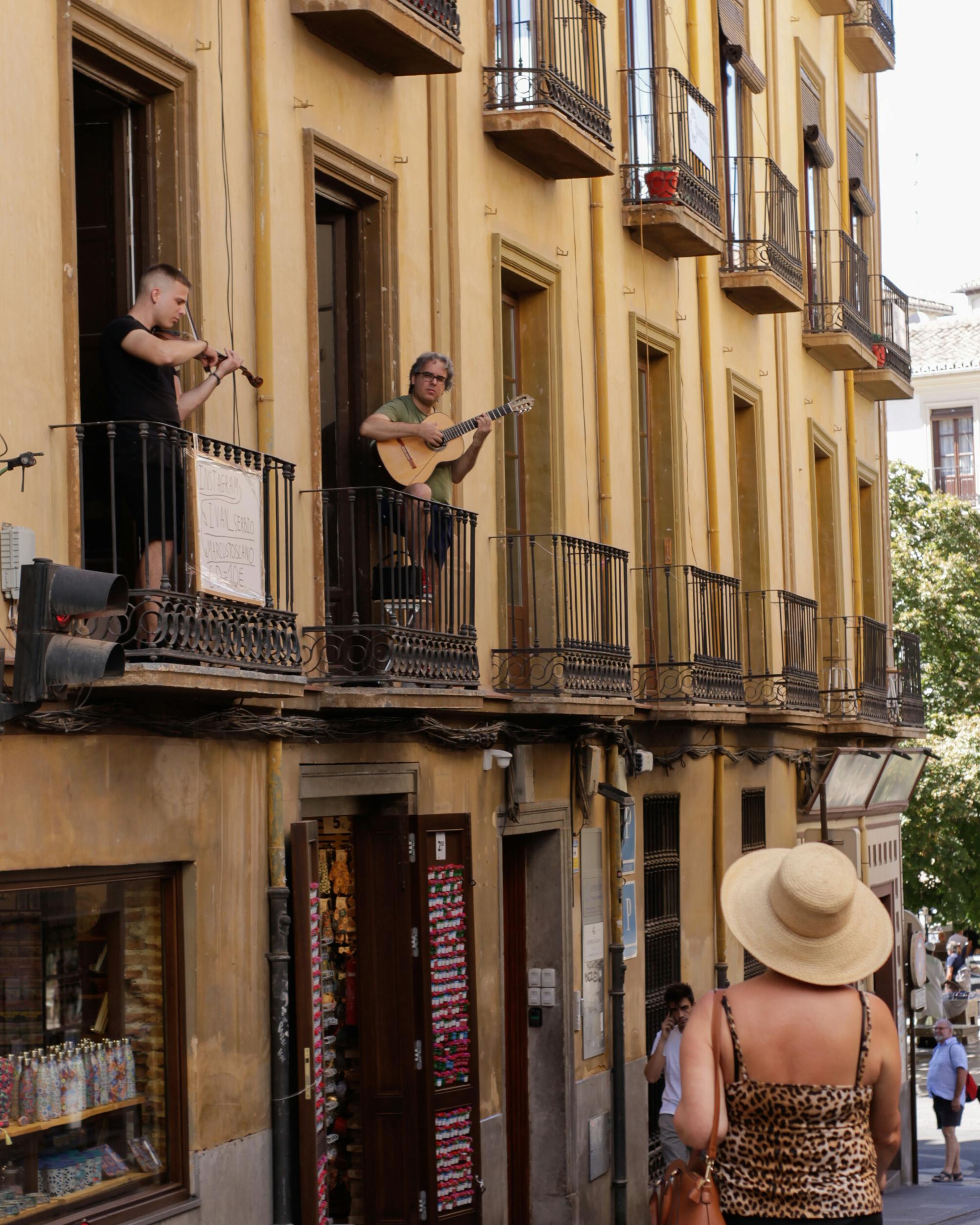 Men Standing on Balconies and Playing Music · Free Stock Photo
