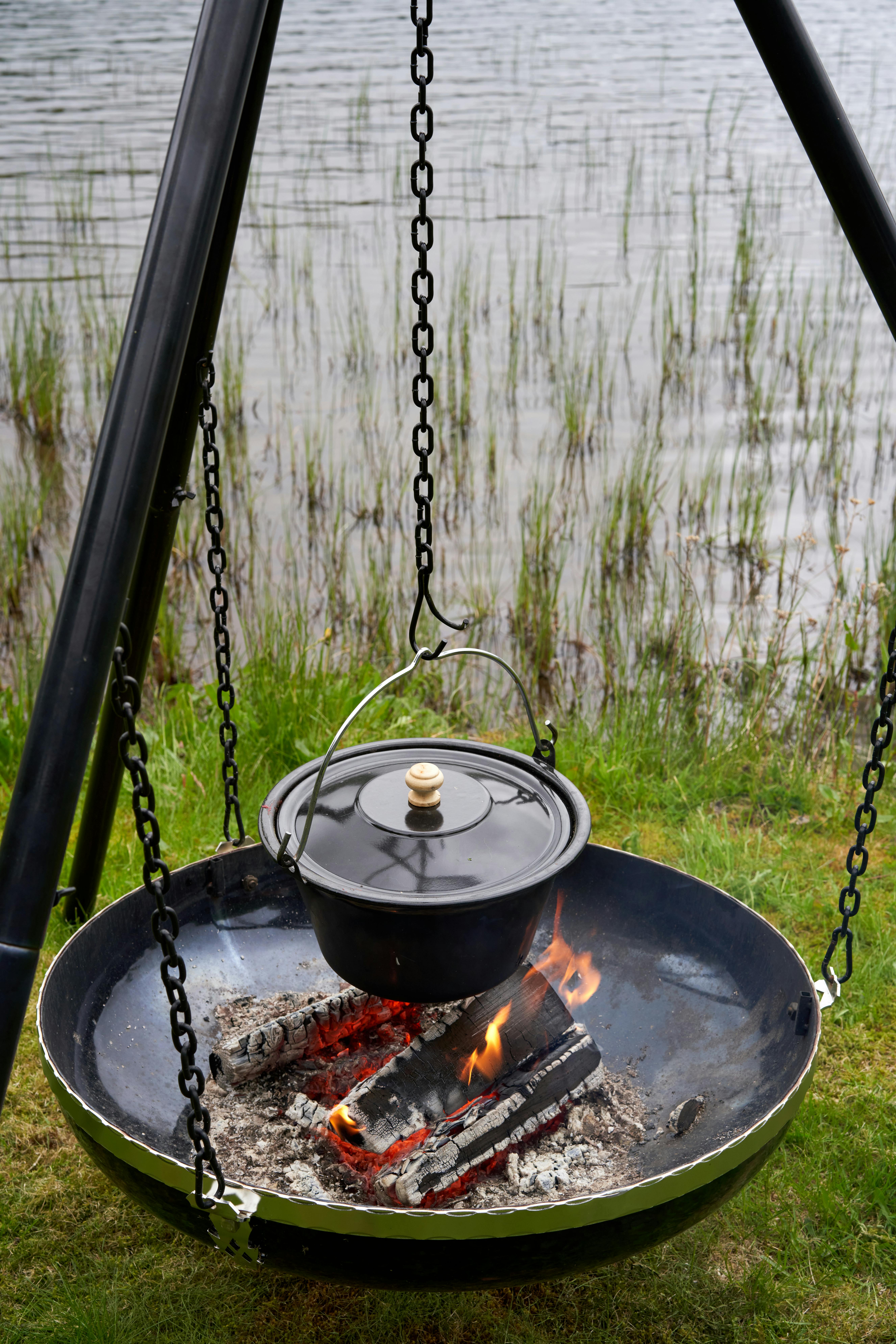 Cooking in Pot on Fire near Lake in Nature · Free Stock Photo