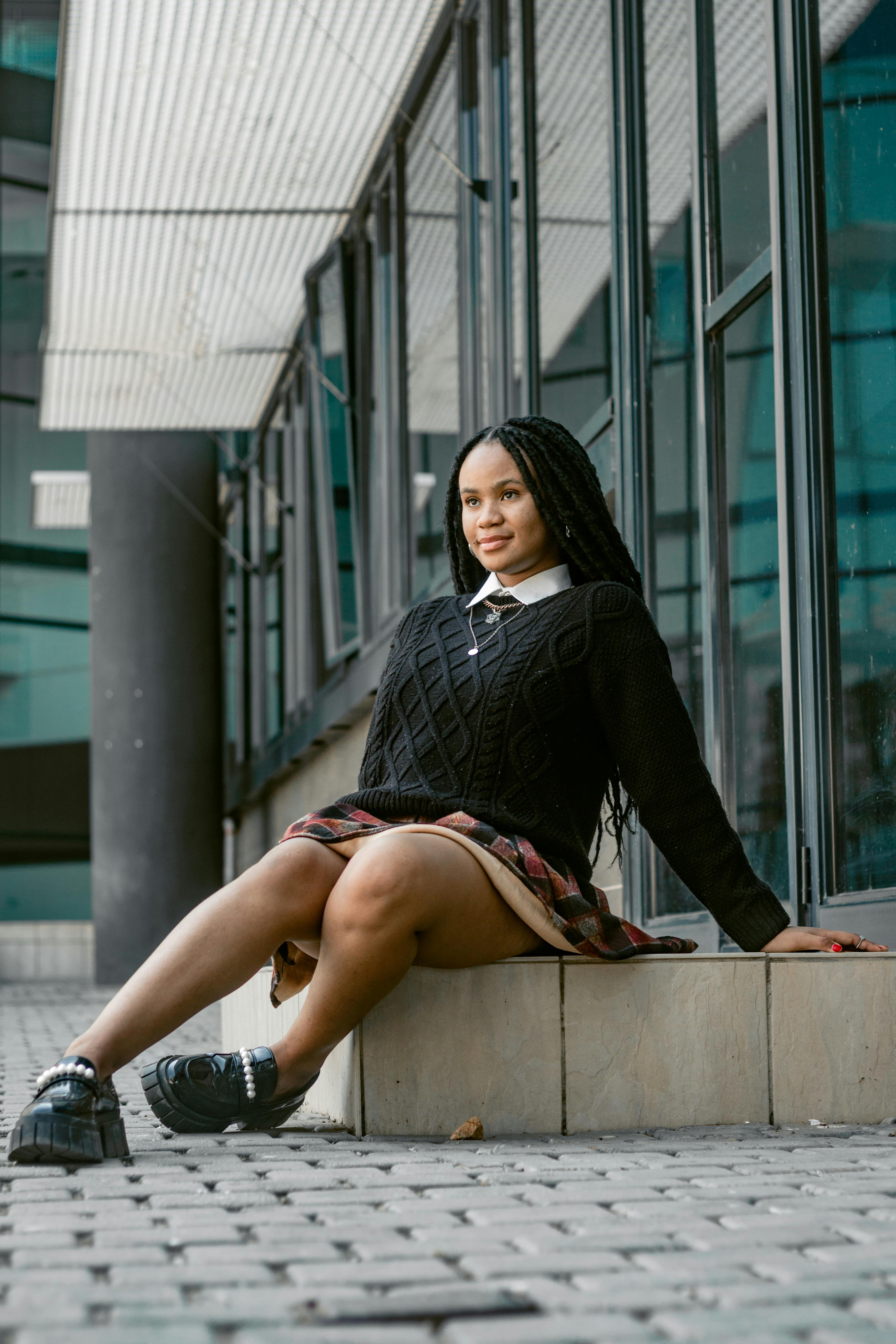 A Woman in Black Sweater Sitting on a Concrete Step while Looking Afar ...