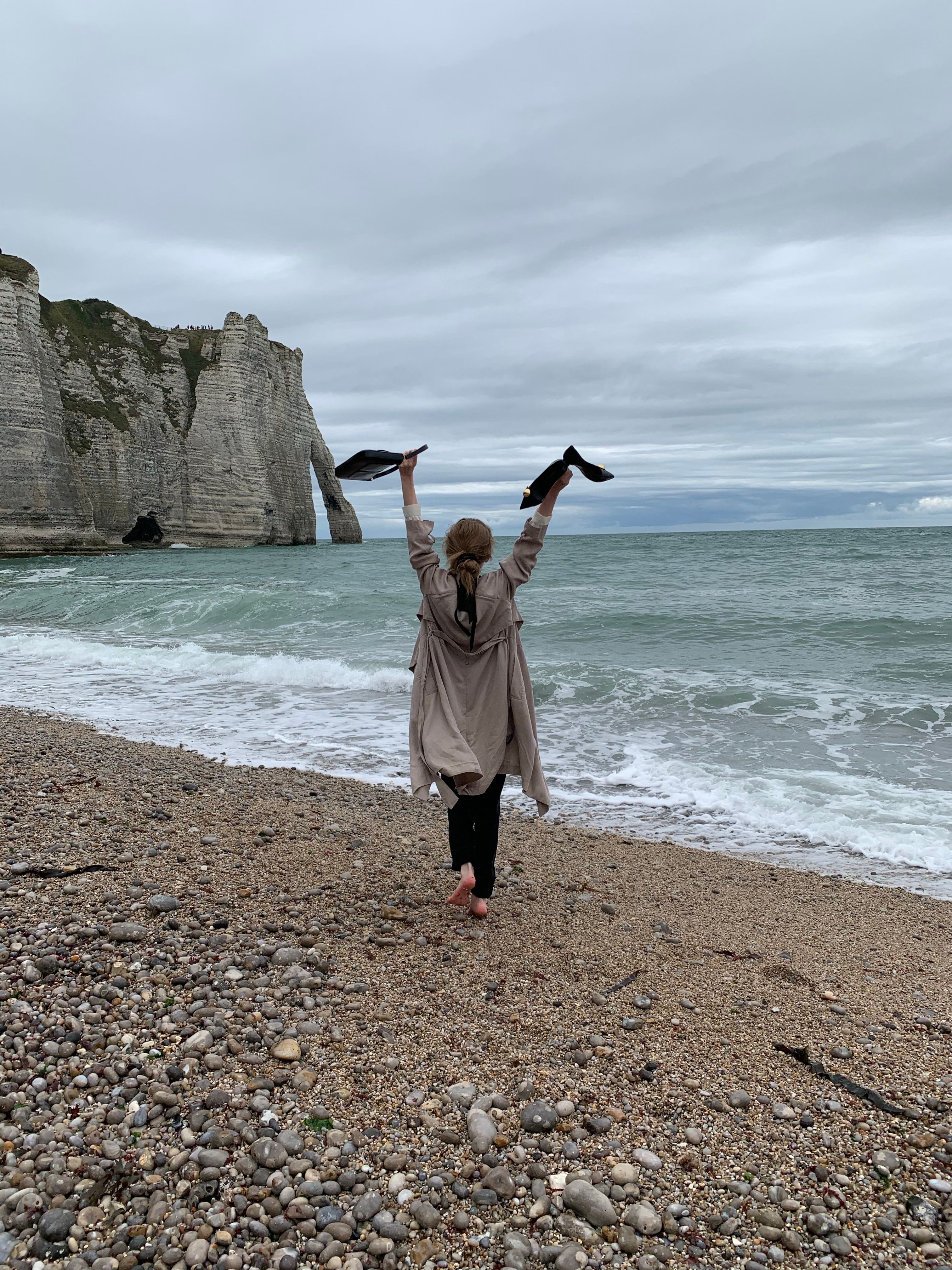 Back View of Person Posing on Windswept Beach · Free Stock Photo