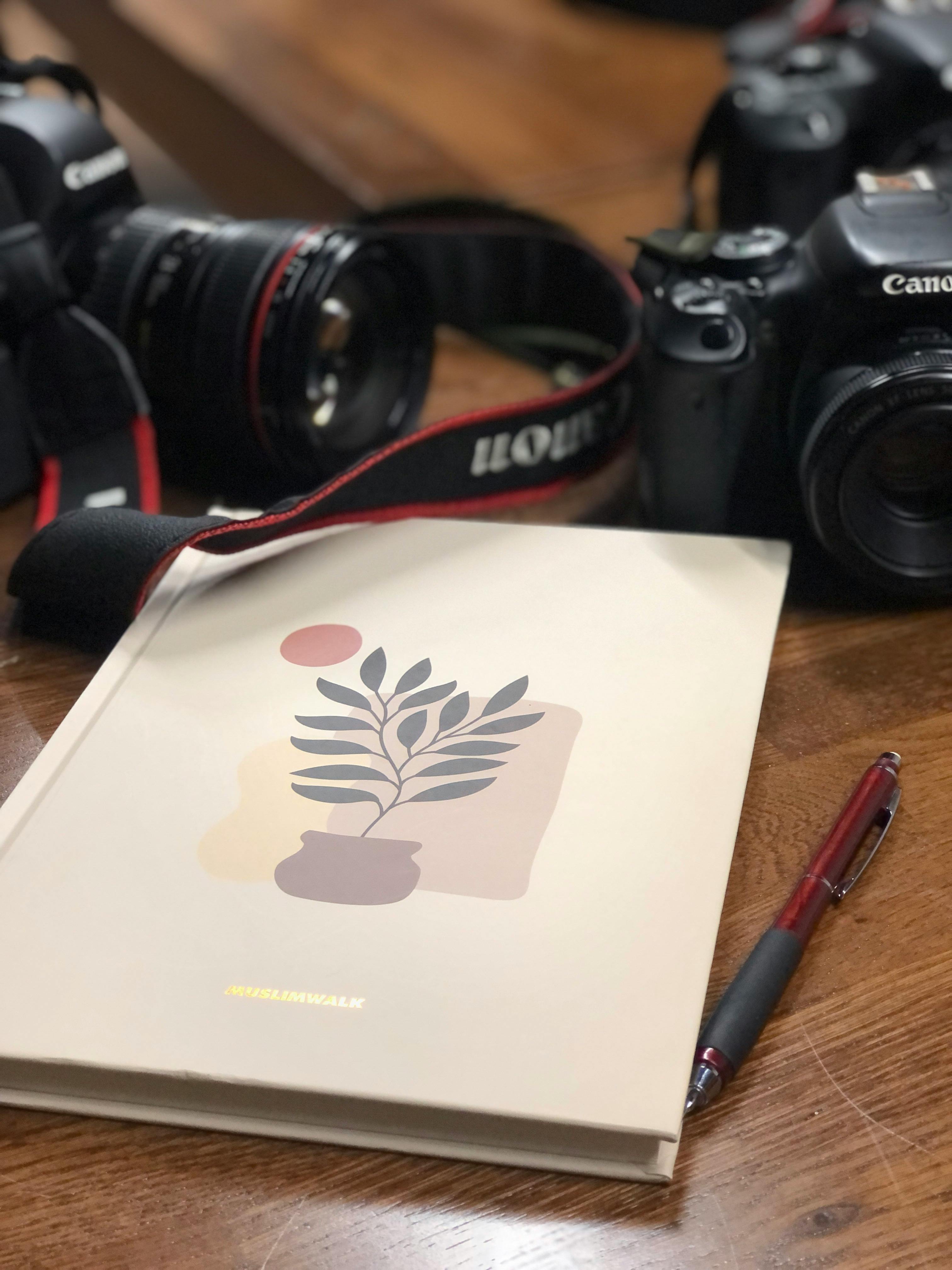 A Cameras and Notebook on a Wooden Table · Free Stock Photo