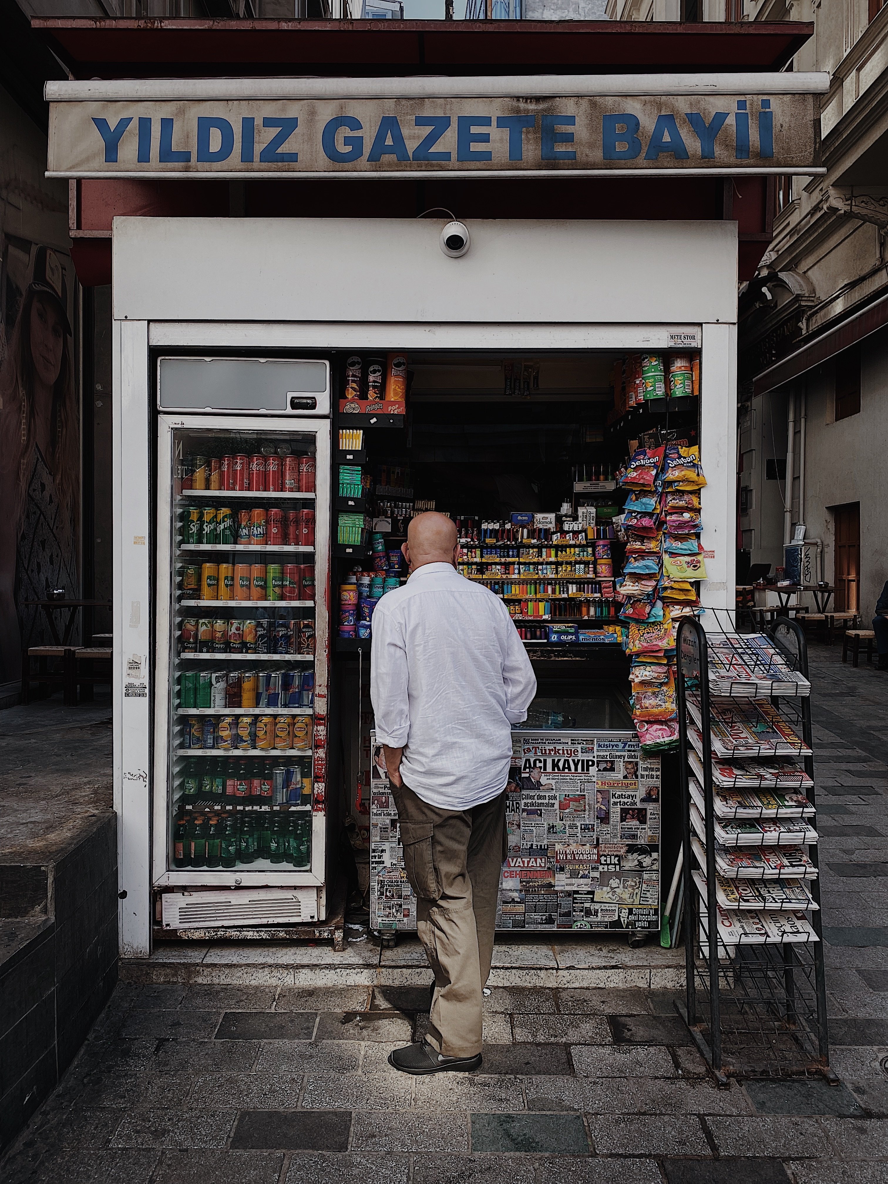 Man Standing in Front of a a Newsstand · Free Stock Photo
