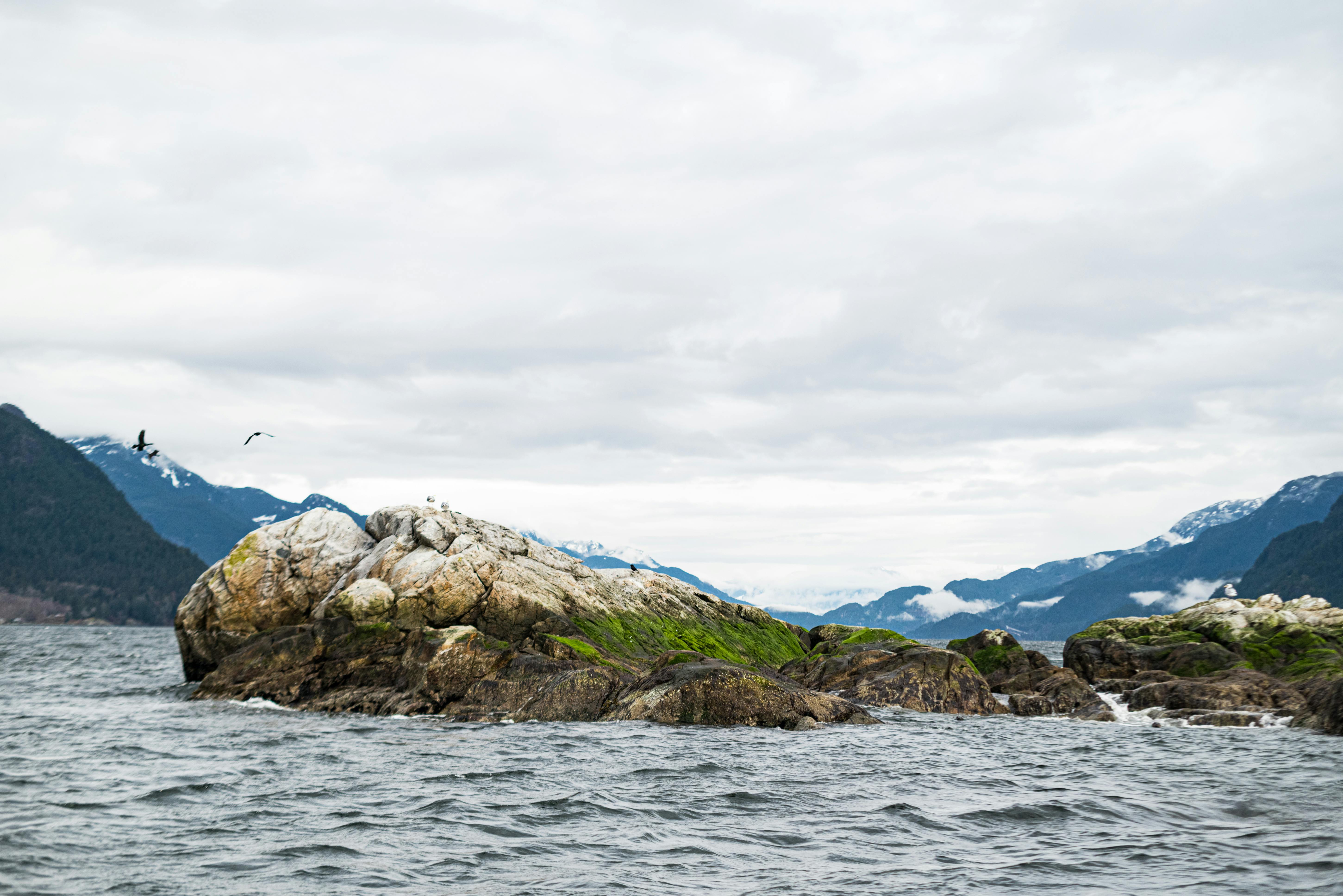Rocky Islet in a Bay Surrounded by Mountains · Free Stock Photo