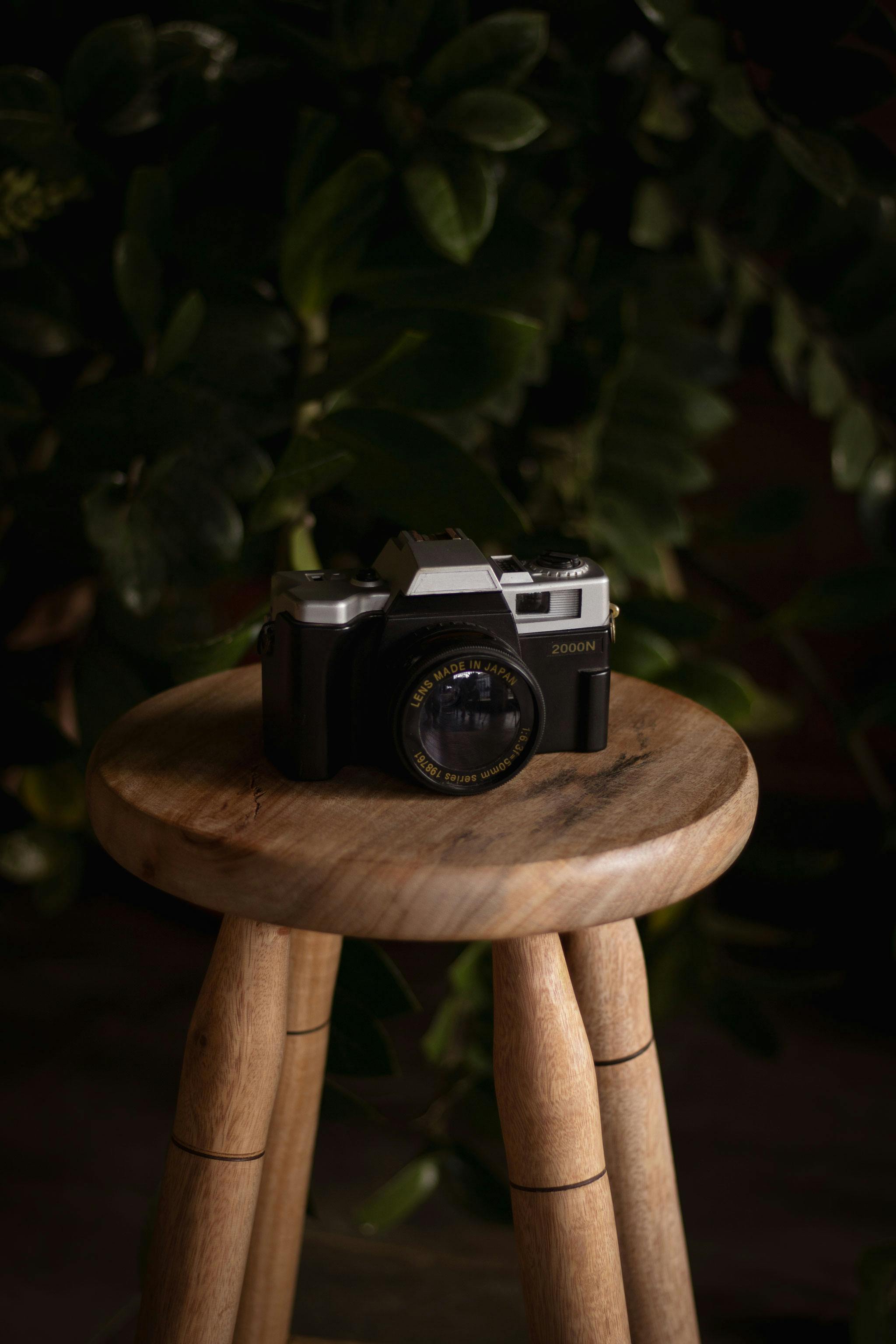 Black and Silver DSLR Camera on Brown Wooden Chair · Free Stock Photo