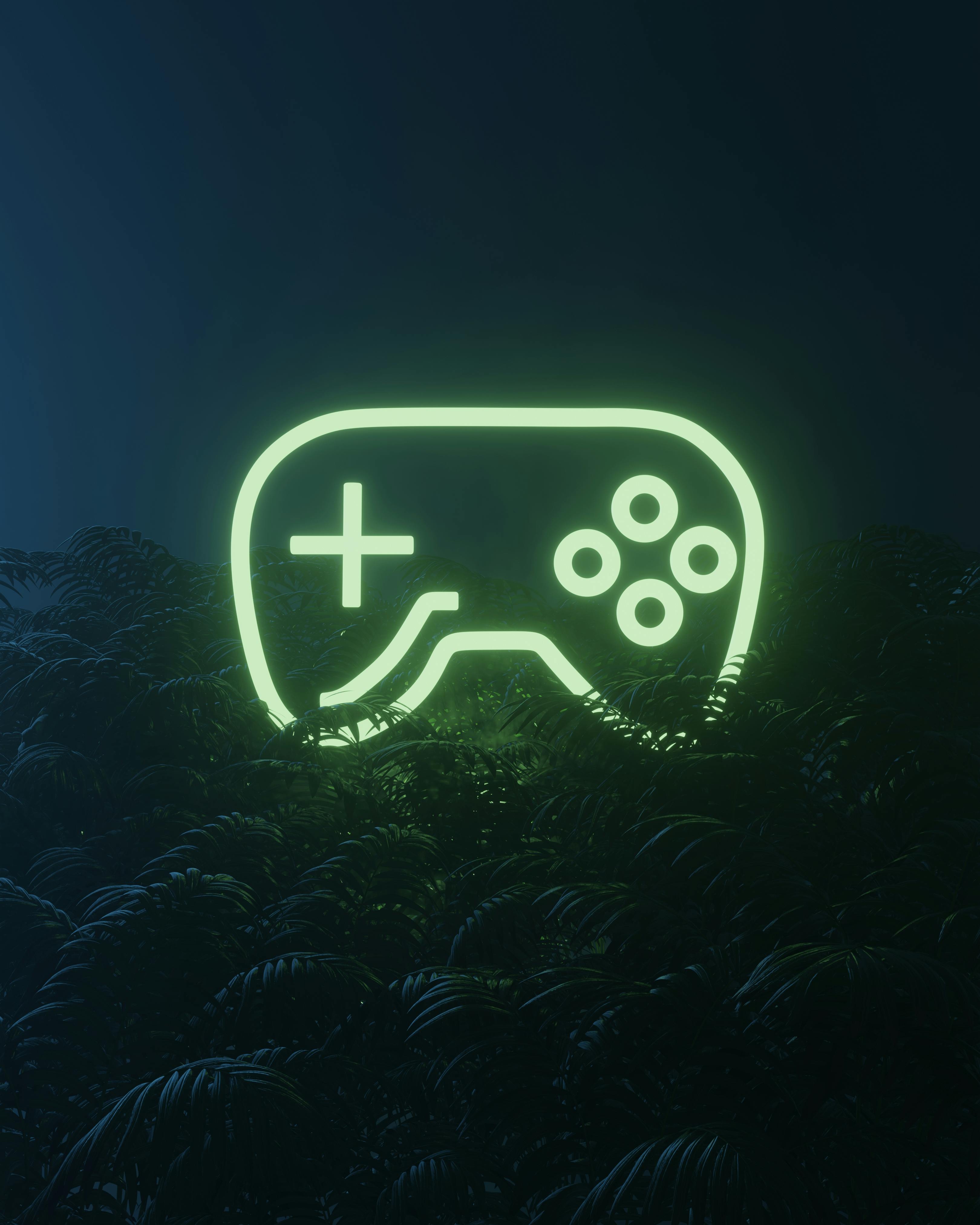 Neon Game Controller Icon Amidst Dark Foliage · Free Stock Photo