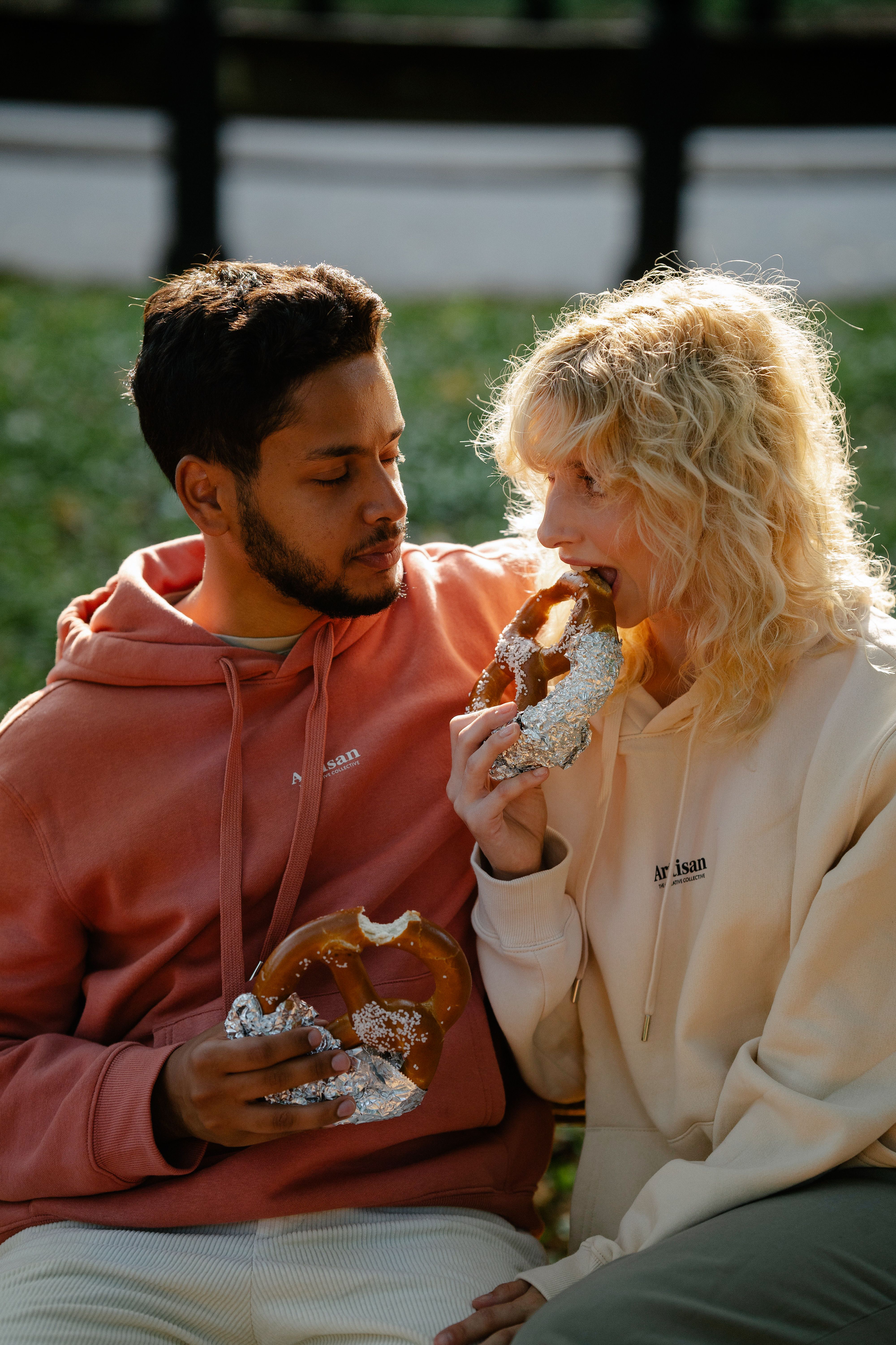 Woman and Man Sitting and Eating Pretzels · Free Stock Photo