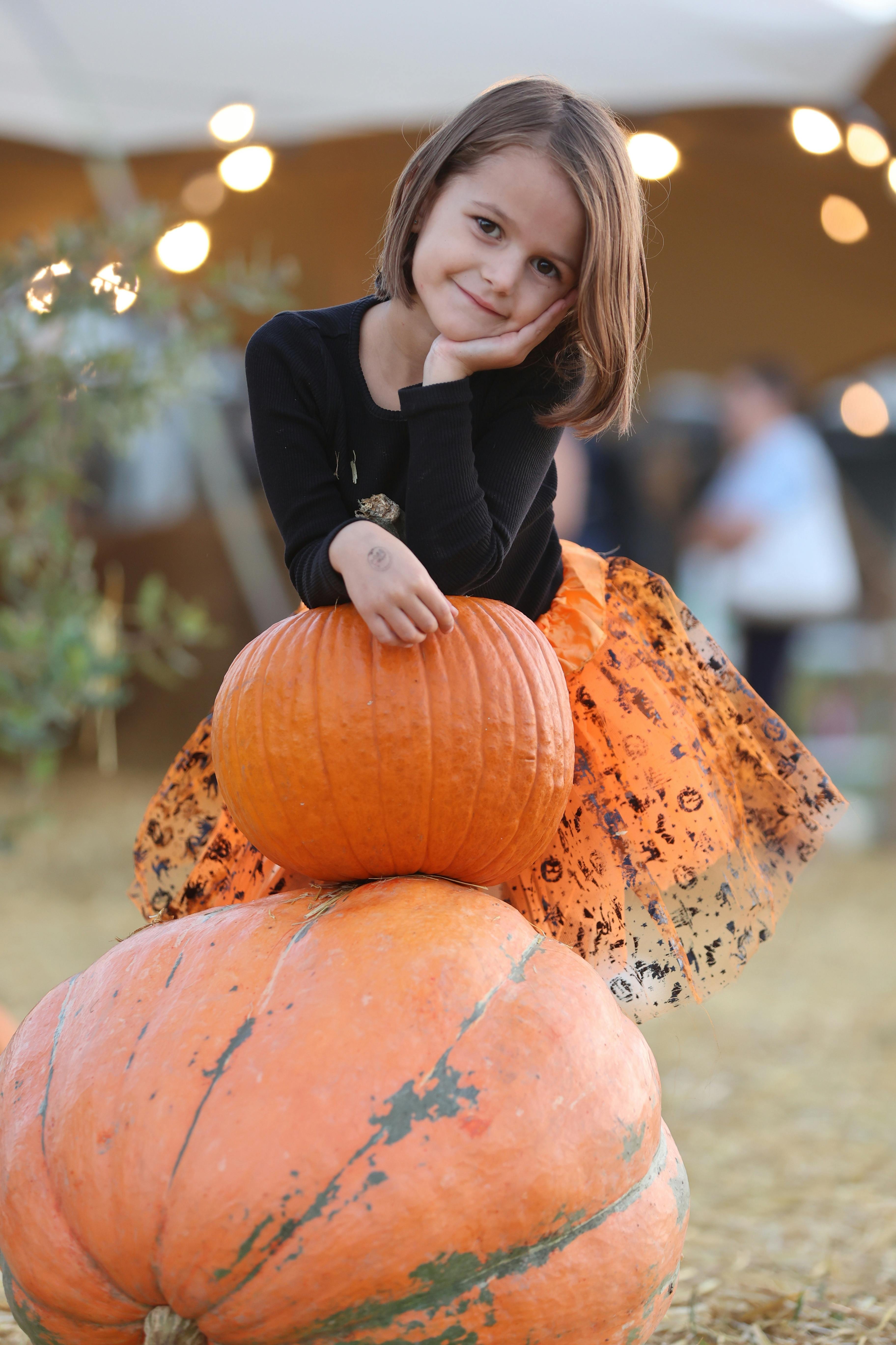 Smiling Girl Posing with Pumpkins · Free Stock Photo