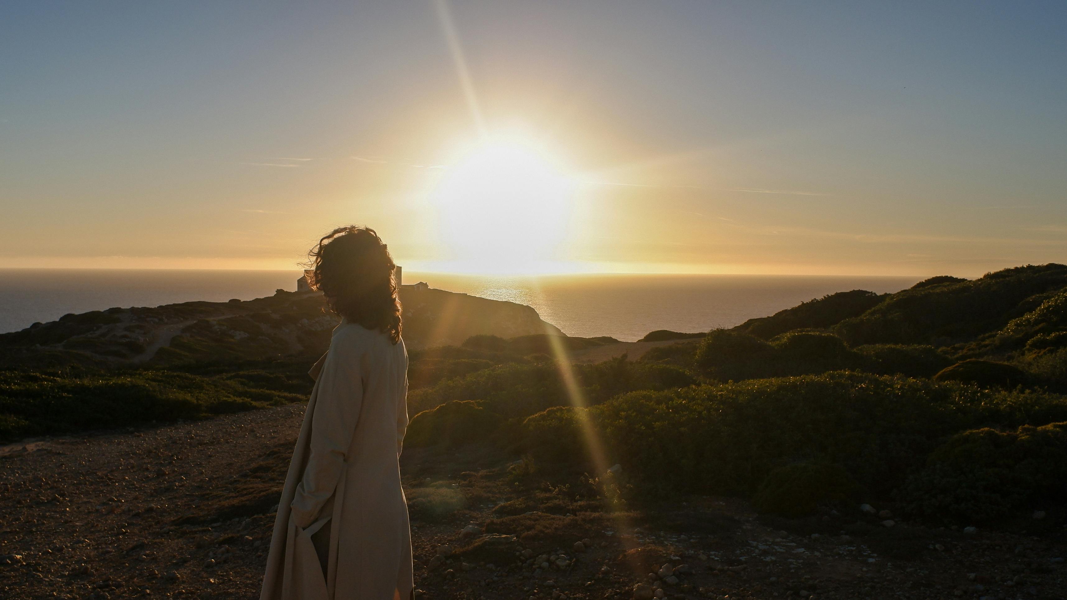 A Person in Trench Coat Looking at the Beautiful Sunset · Free Stock Photo