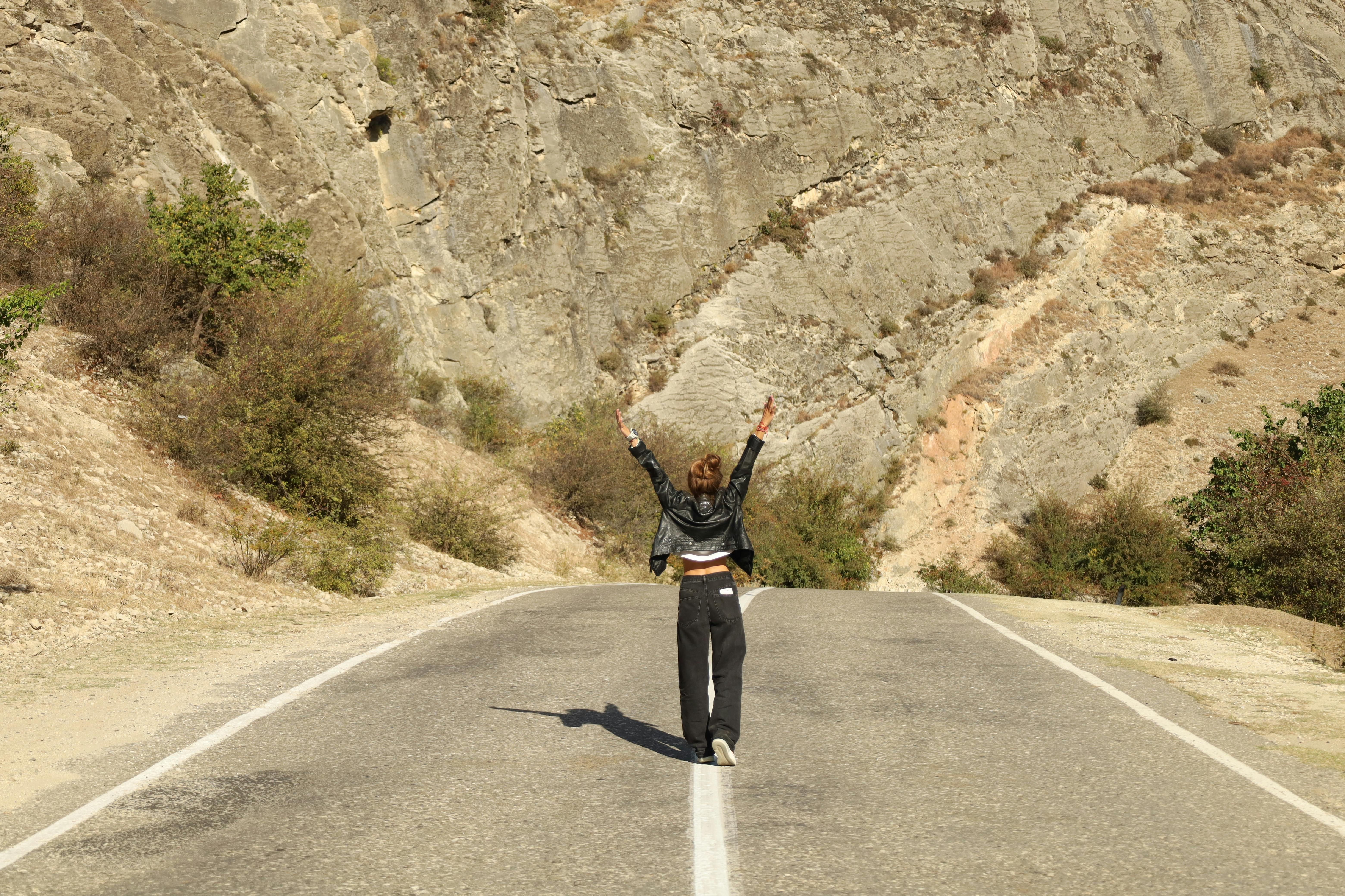 Person Walking on Road Near Trees · Free Stock Photo