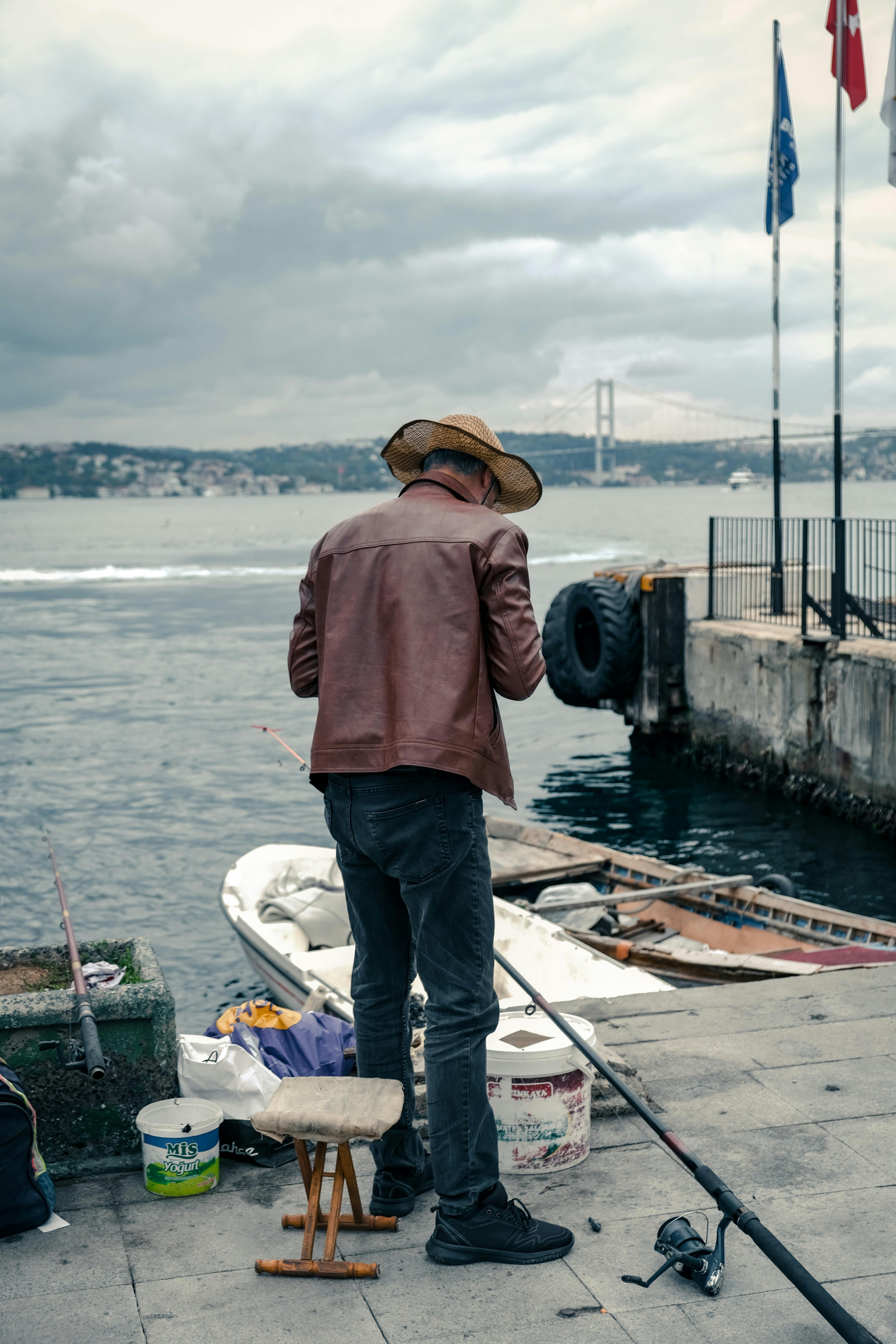 Man in Brown Leather Jacket Fishing on Riverside · Free Stock Photo