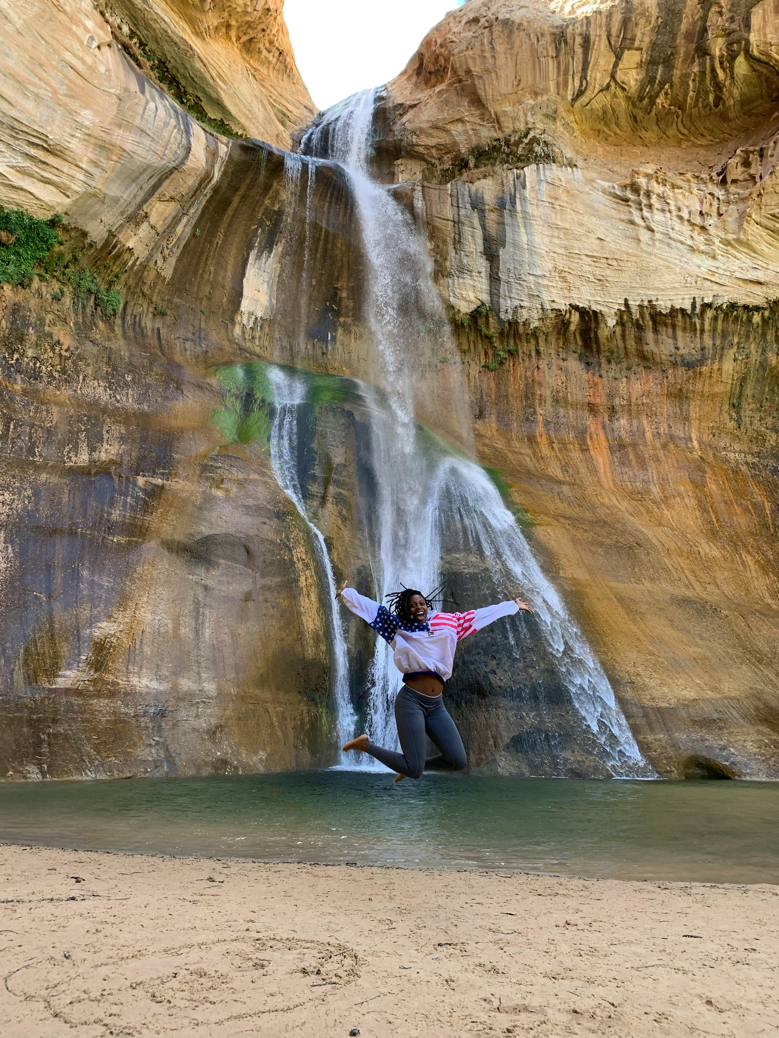 A Woman in Jump Shot Near a Waterfalls · Free Stock Photo