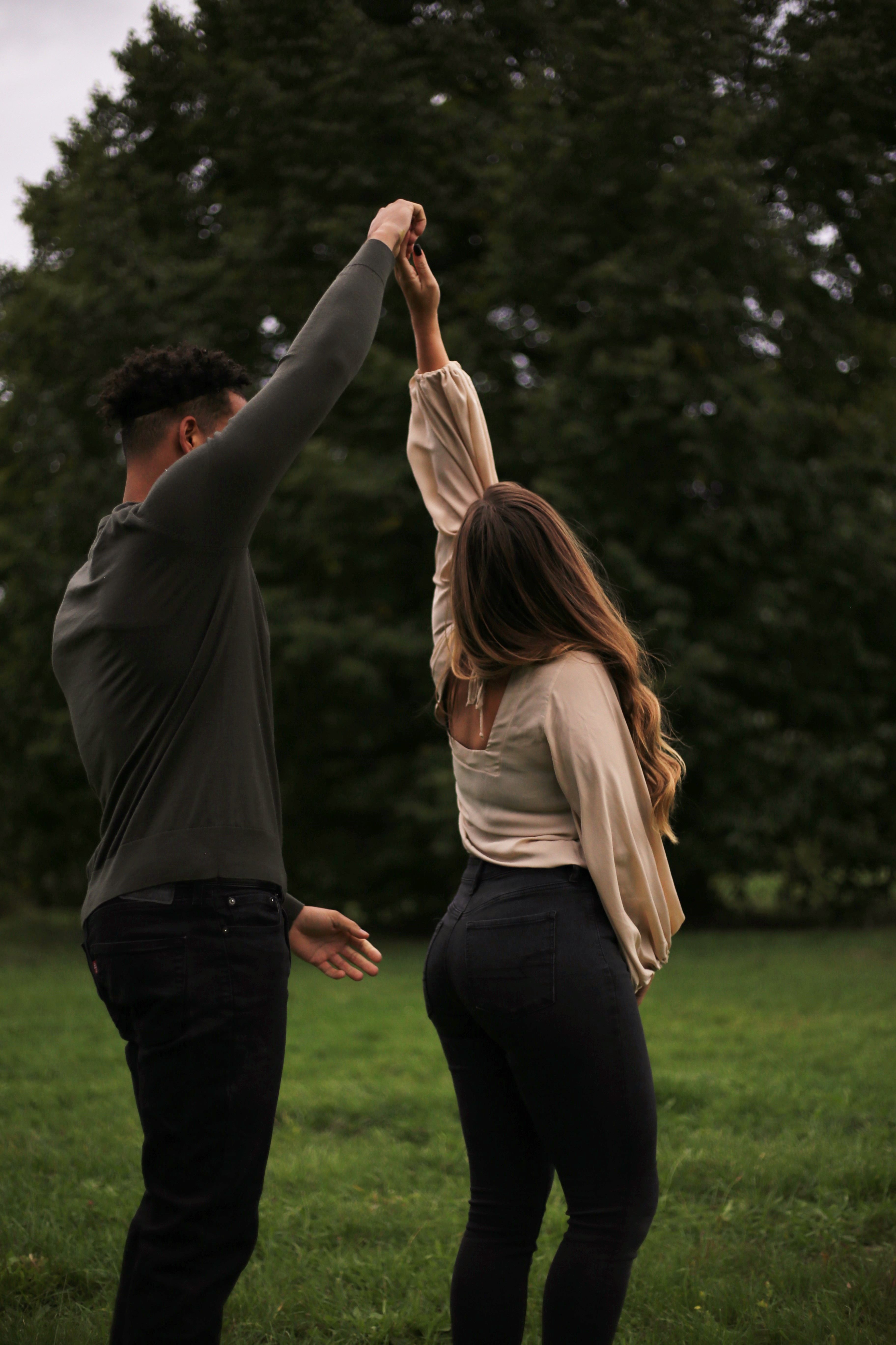 Happy Man and Woman Dancing Holding Hands Outdoors · Free Stock Photo