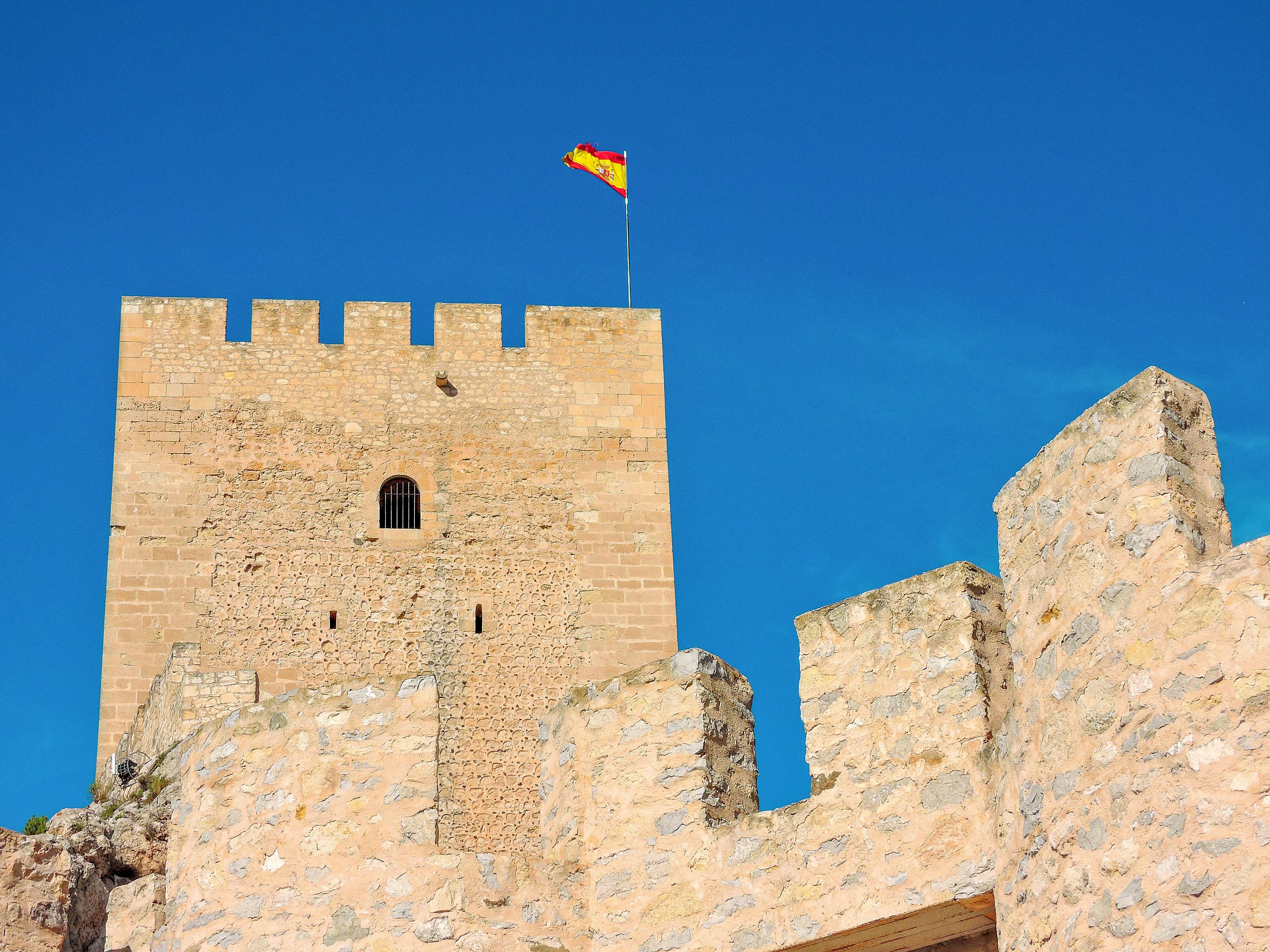A Flag Over a Castle Under a Clear Blue Sky · Free Stock Photo