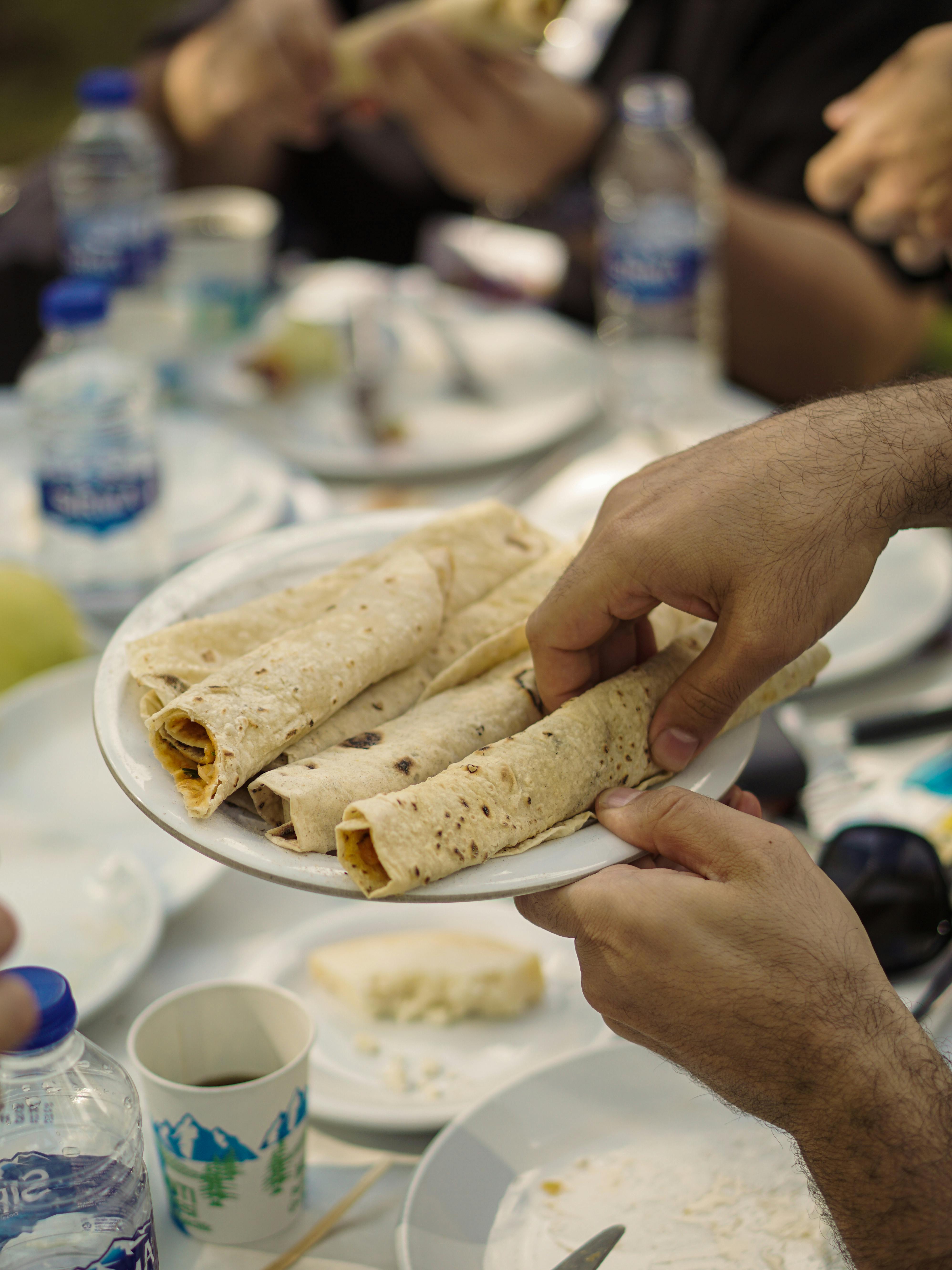 A Hand Putting Burrito on a Ceramic Plate · Free Stock Photo