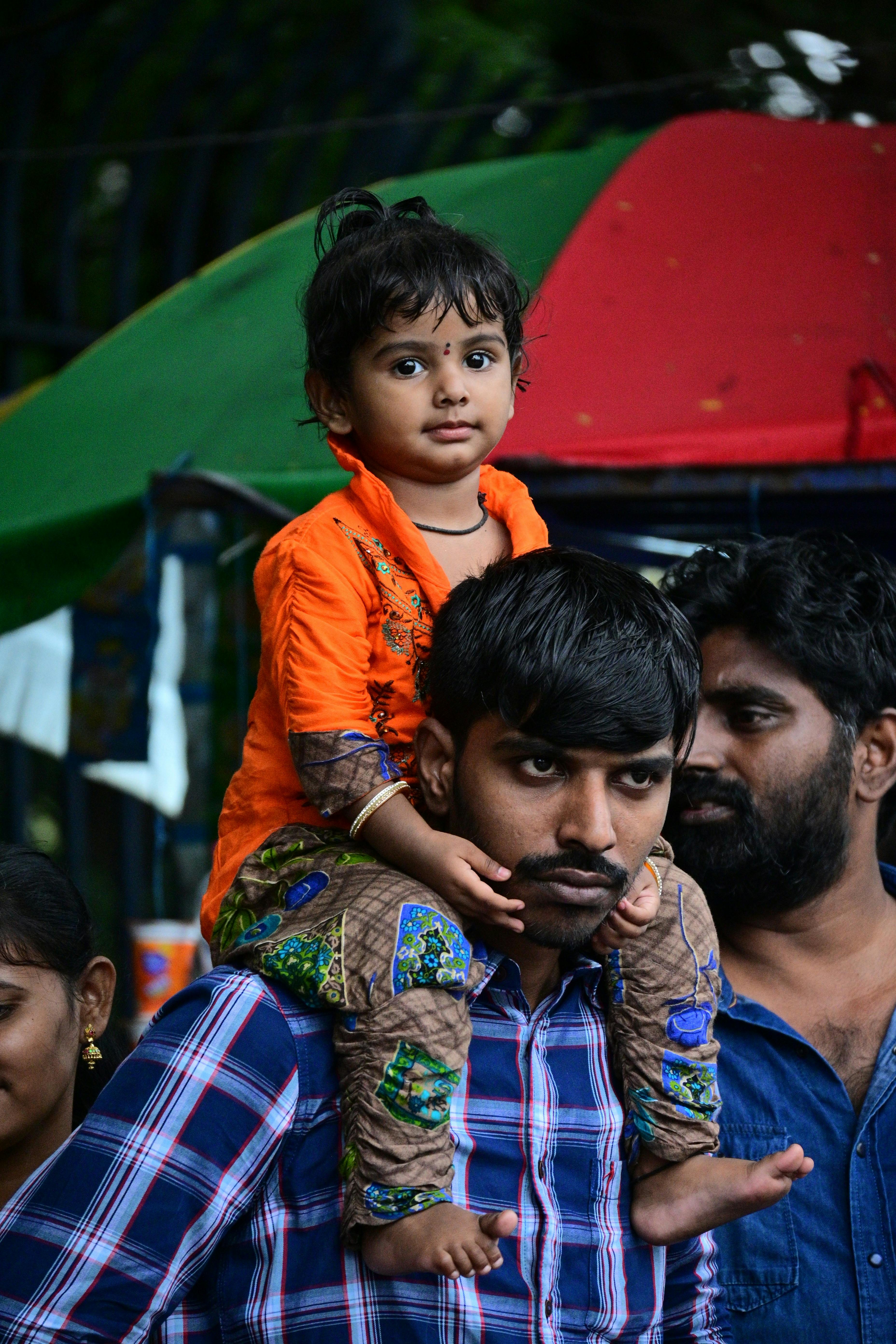 A Cute Kid Sitting on the Man's Shoulders · Free Stock Photo