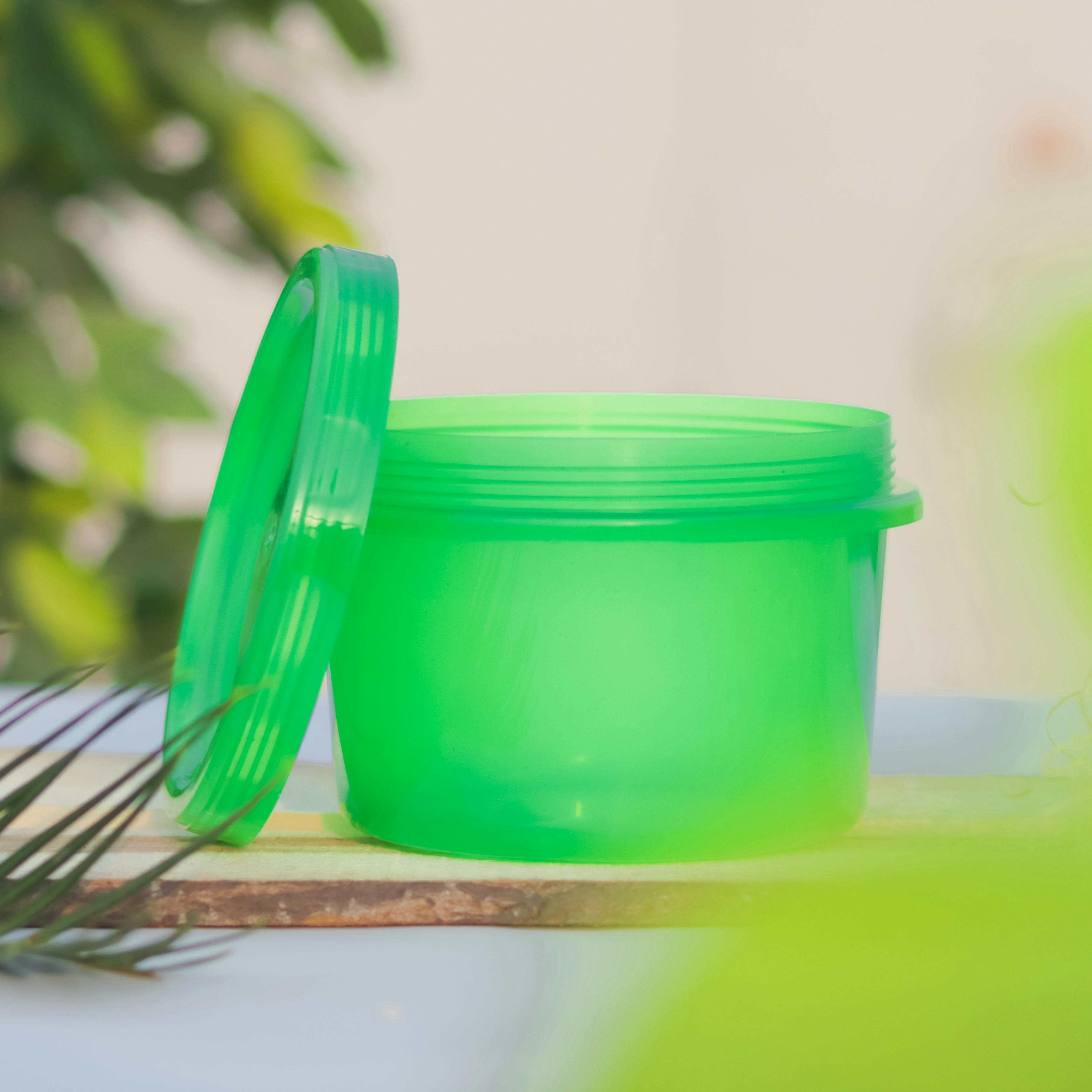 A Green Plastic Container on a Wooden Board · Free Stock Photo