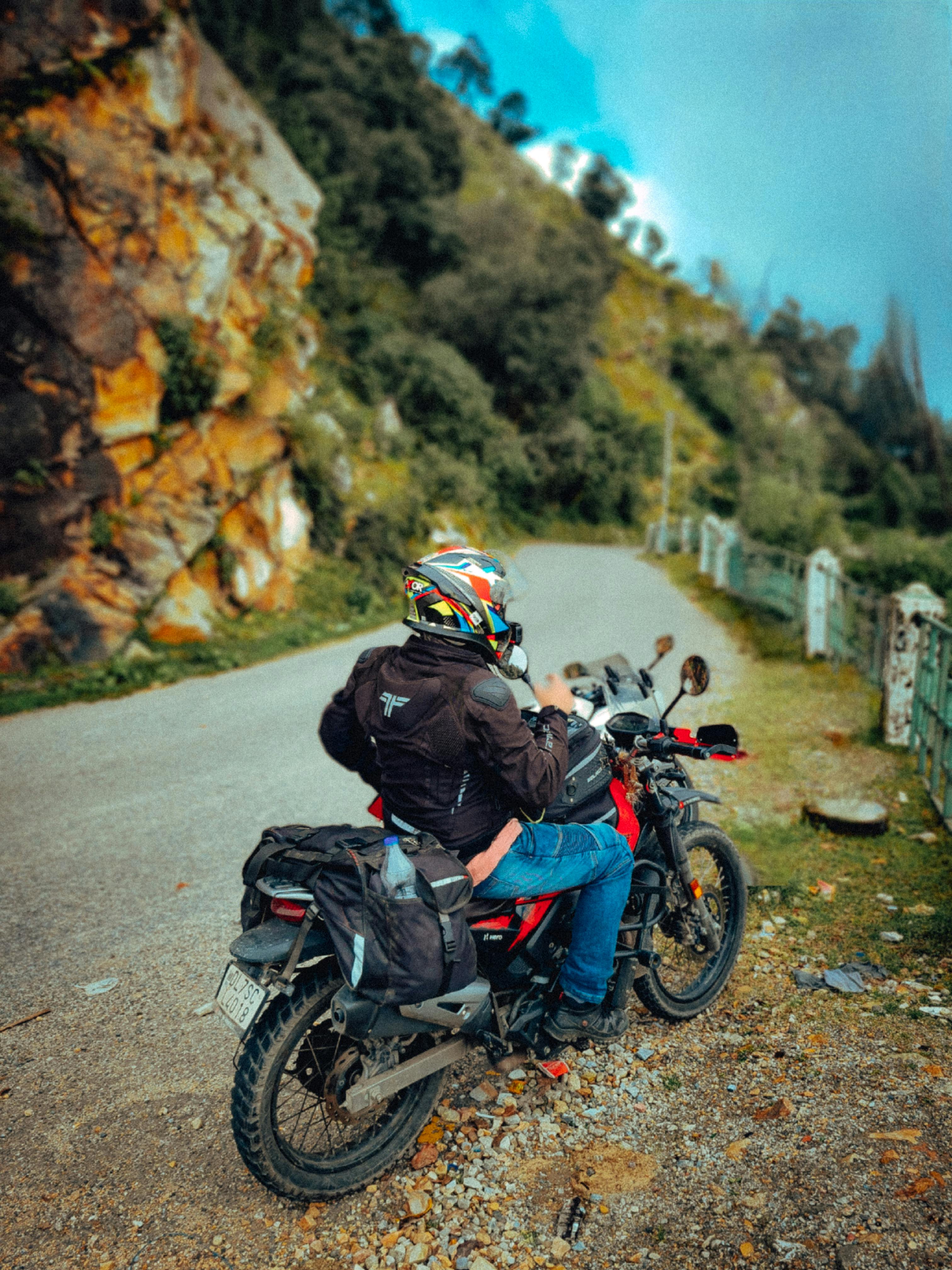 A Person Sitting on a Motorcycle by the Roadside · Free Stock Photo