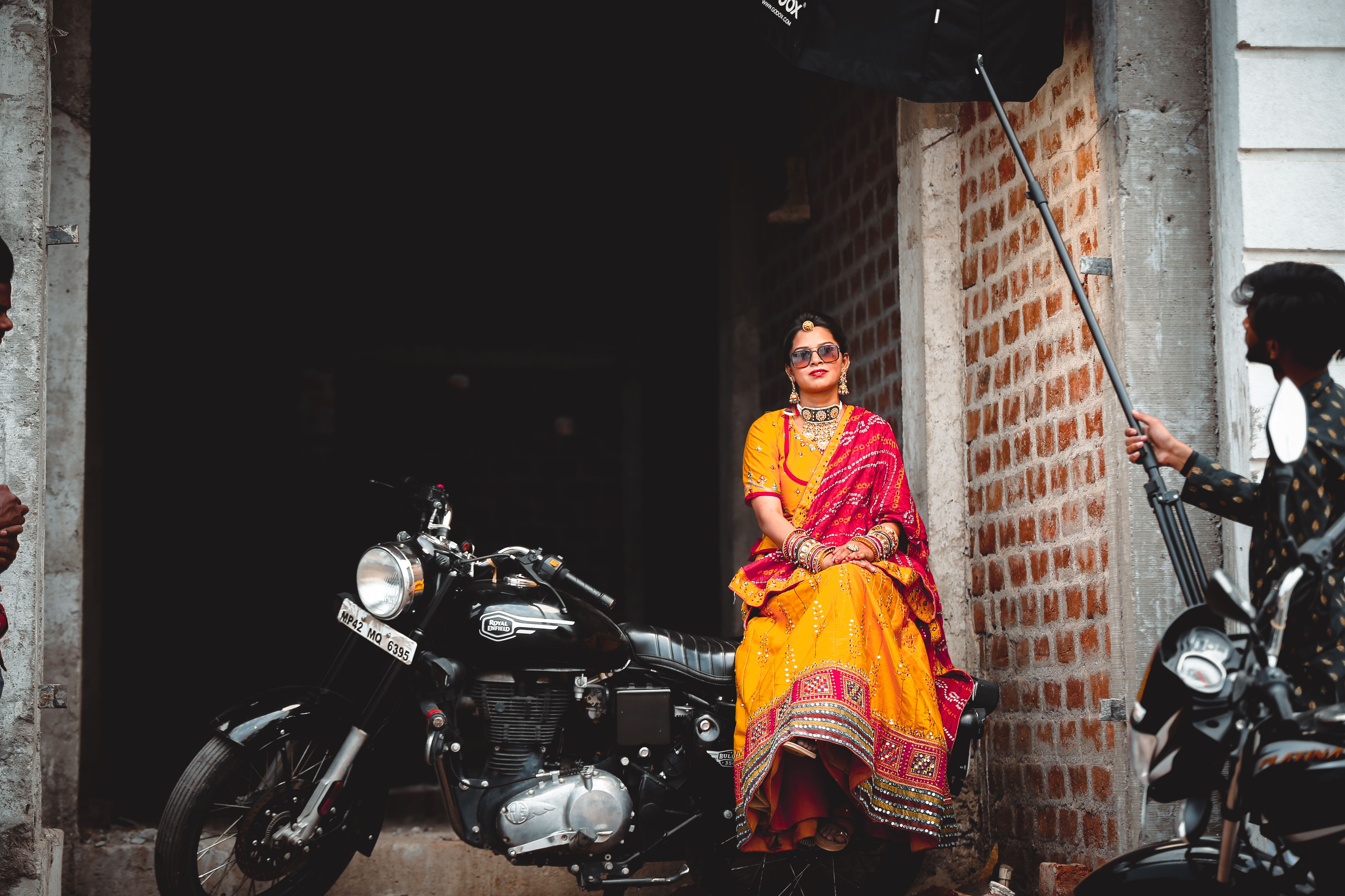 Old Woman in Traditional Dress near Brick Wall · Free Stock Photo