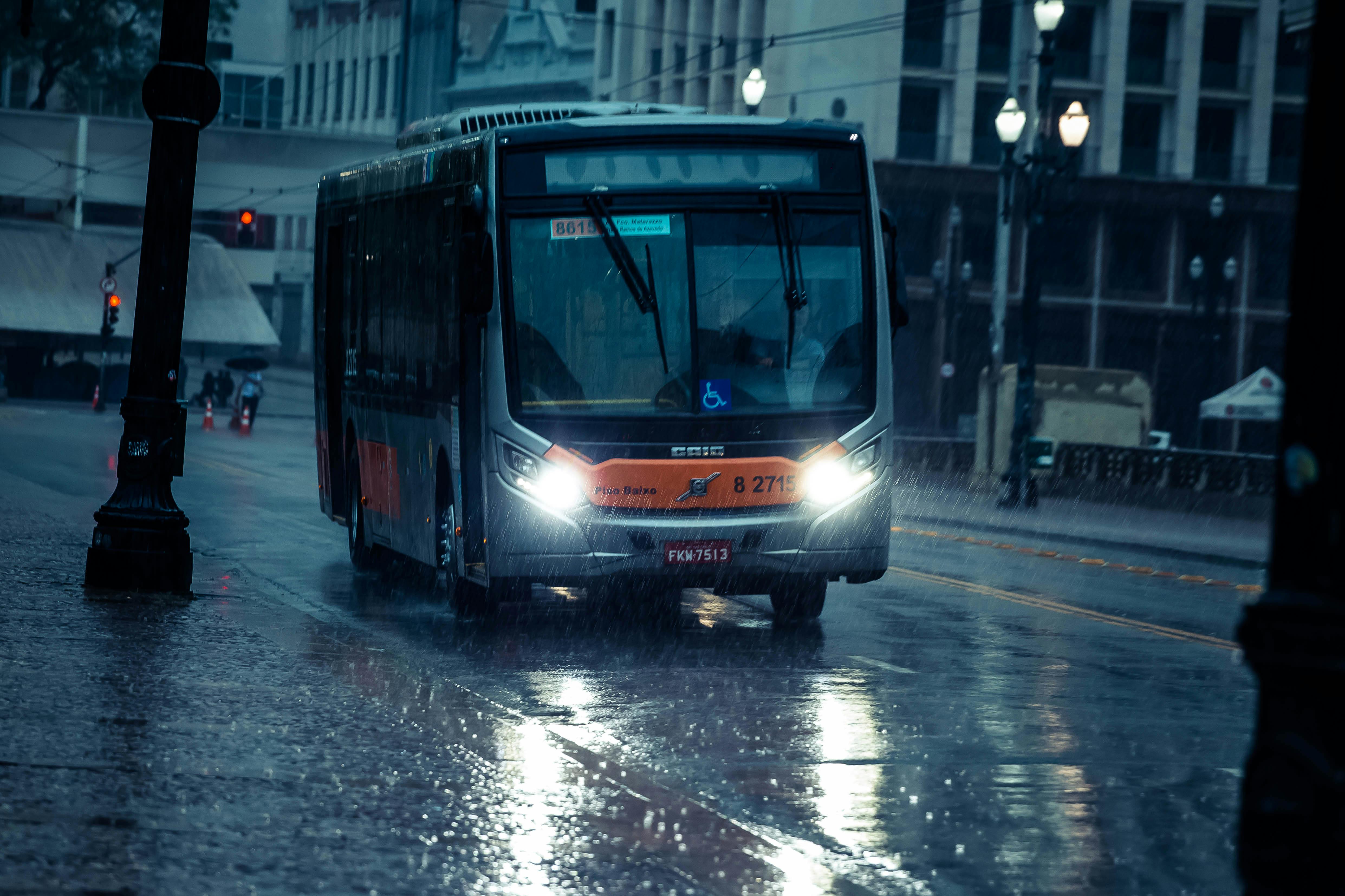 White and Red Bus on Road on a Rainy Day · Free Stock Photo