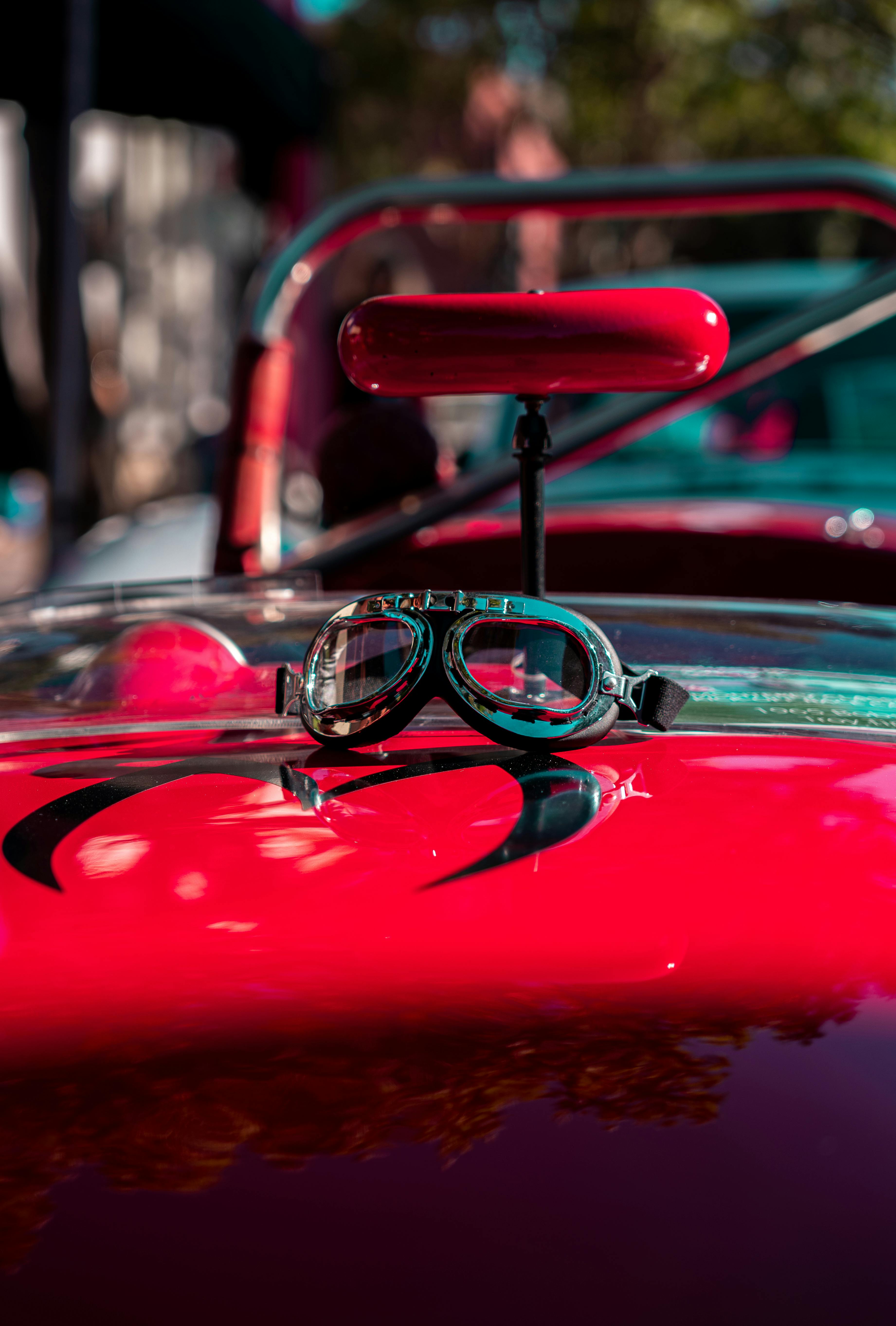Eye Glasses in a Red Car Hood · Free Stock Photo