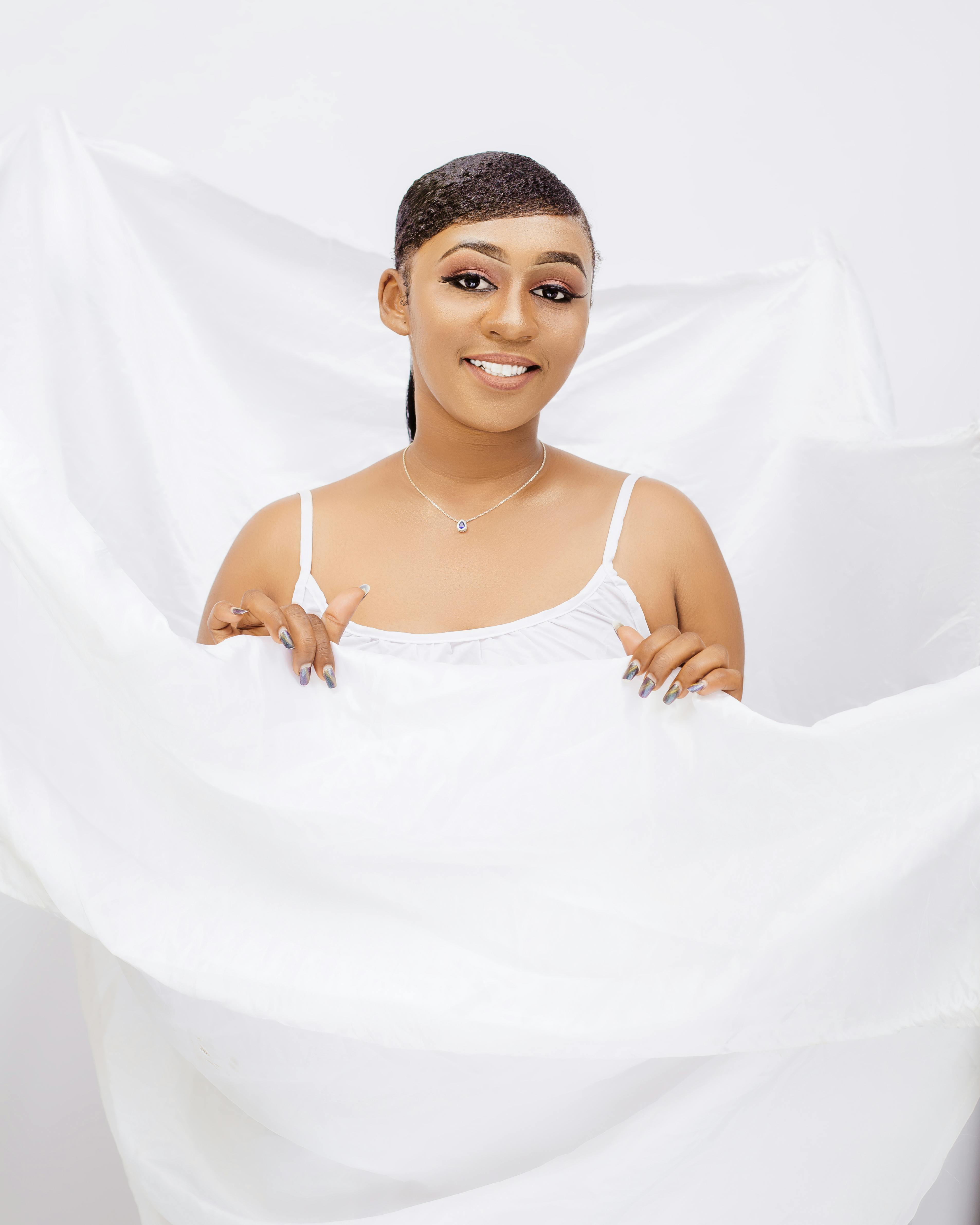 Woman in White Spaghetti Strap Standing Behind White Fabric while ...