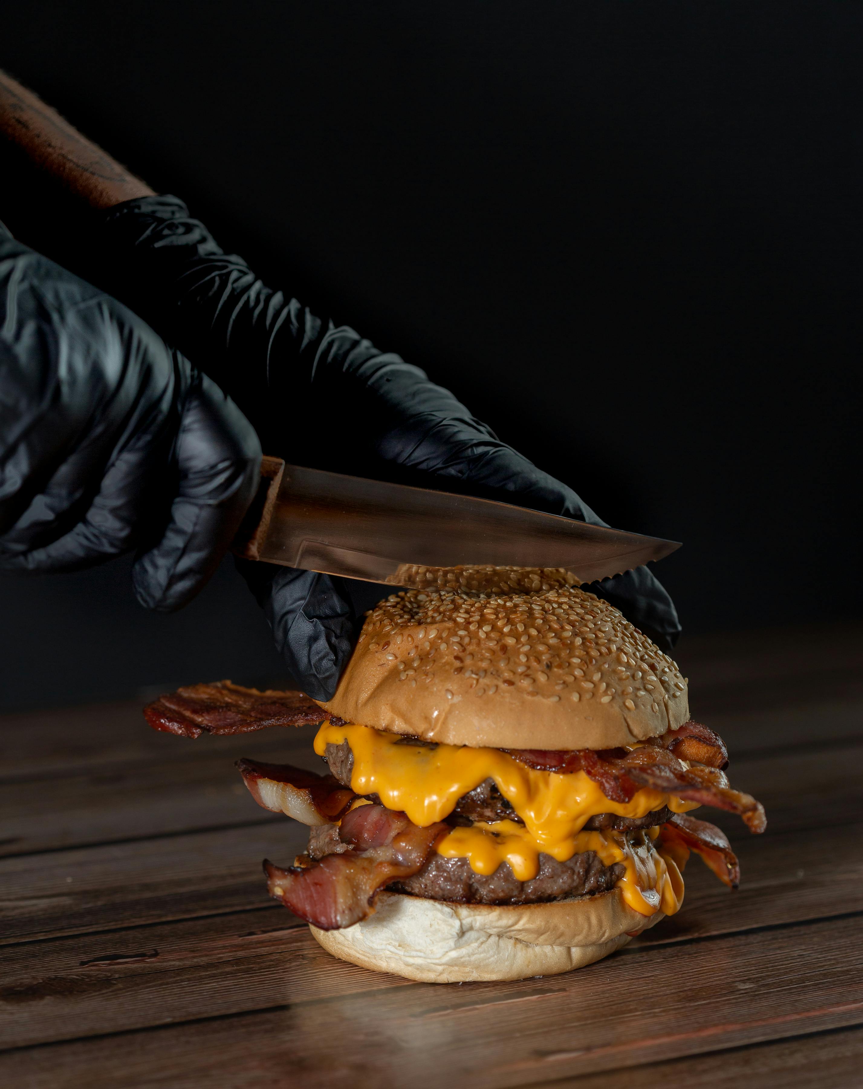 A Close-Up Shot of a Person Slicing a Hamburger · Free Stock Photo