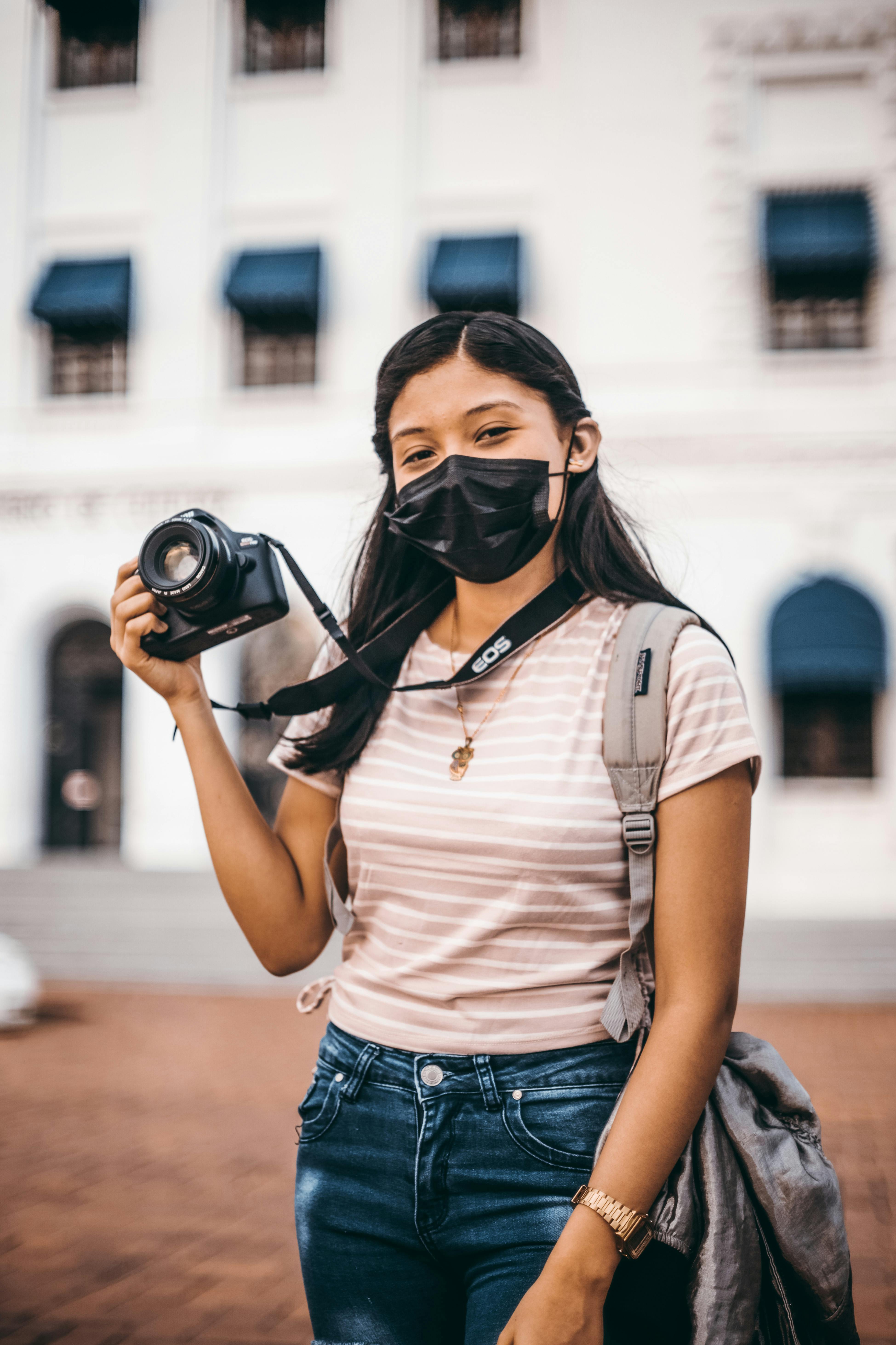 A Woman Wearing Face Mask While Holding Camera · Free Stock Photo