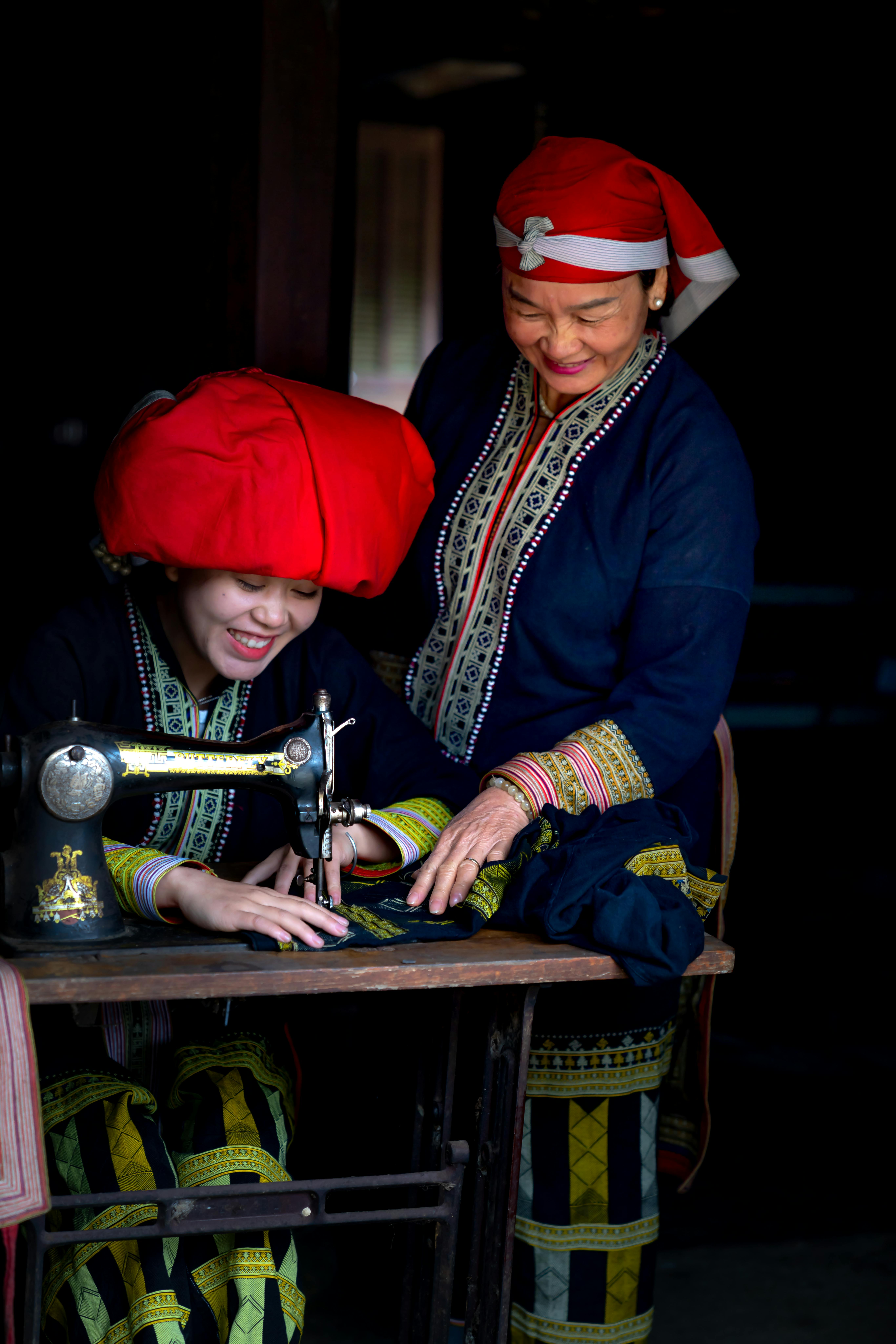 Women in Traditional Clothes Using Sewing Machine · Free Stock Photo