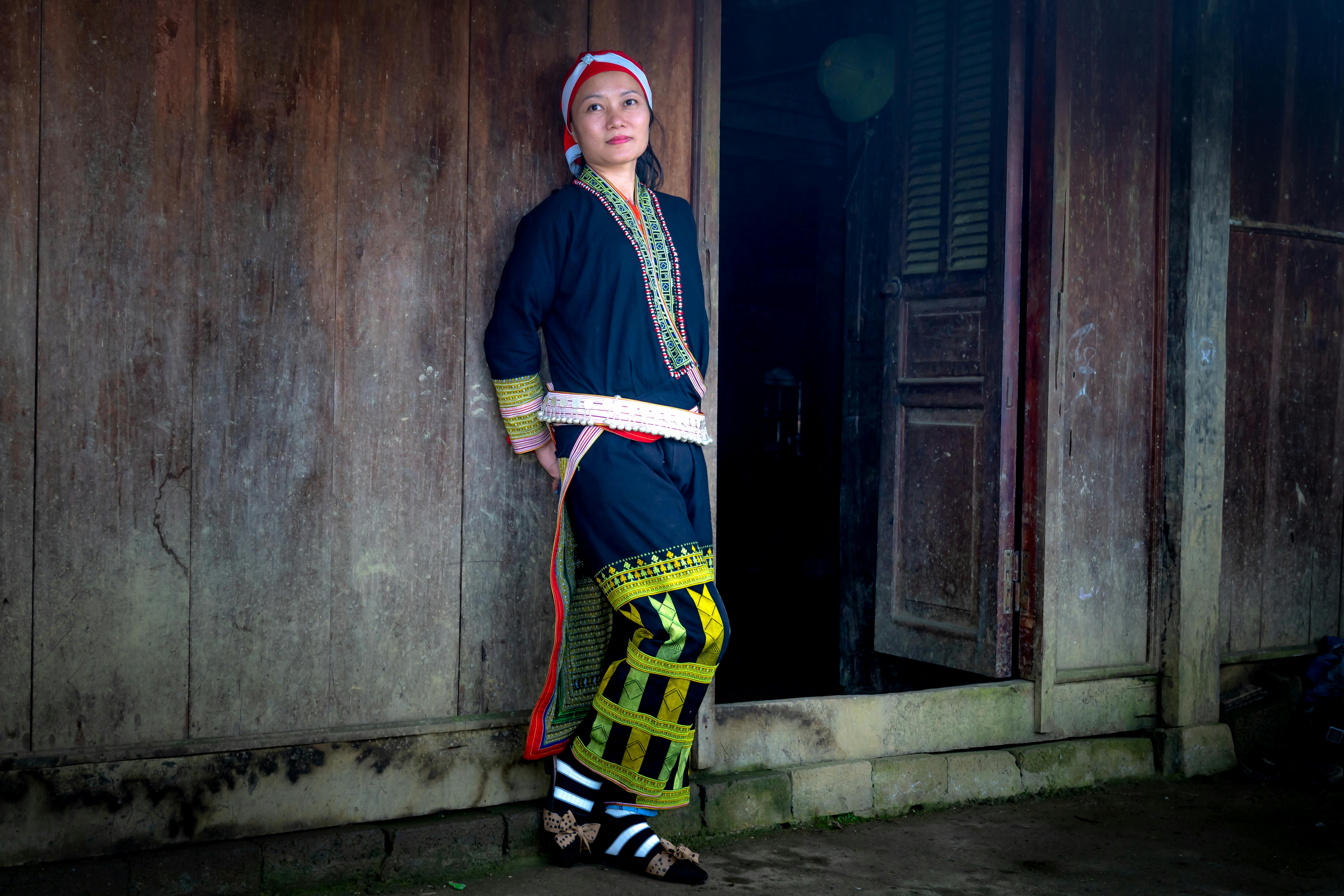 Woman in Traditional Costume Standing near Wooden House · Free Stock Photo
