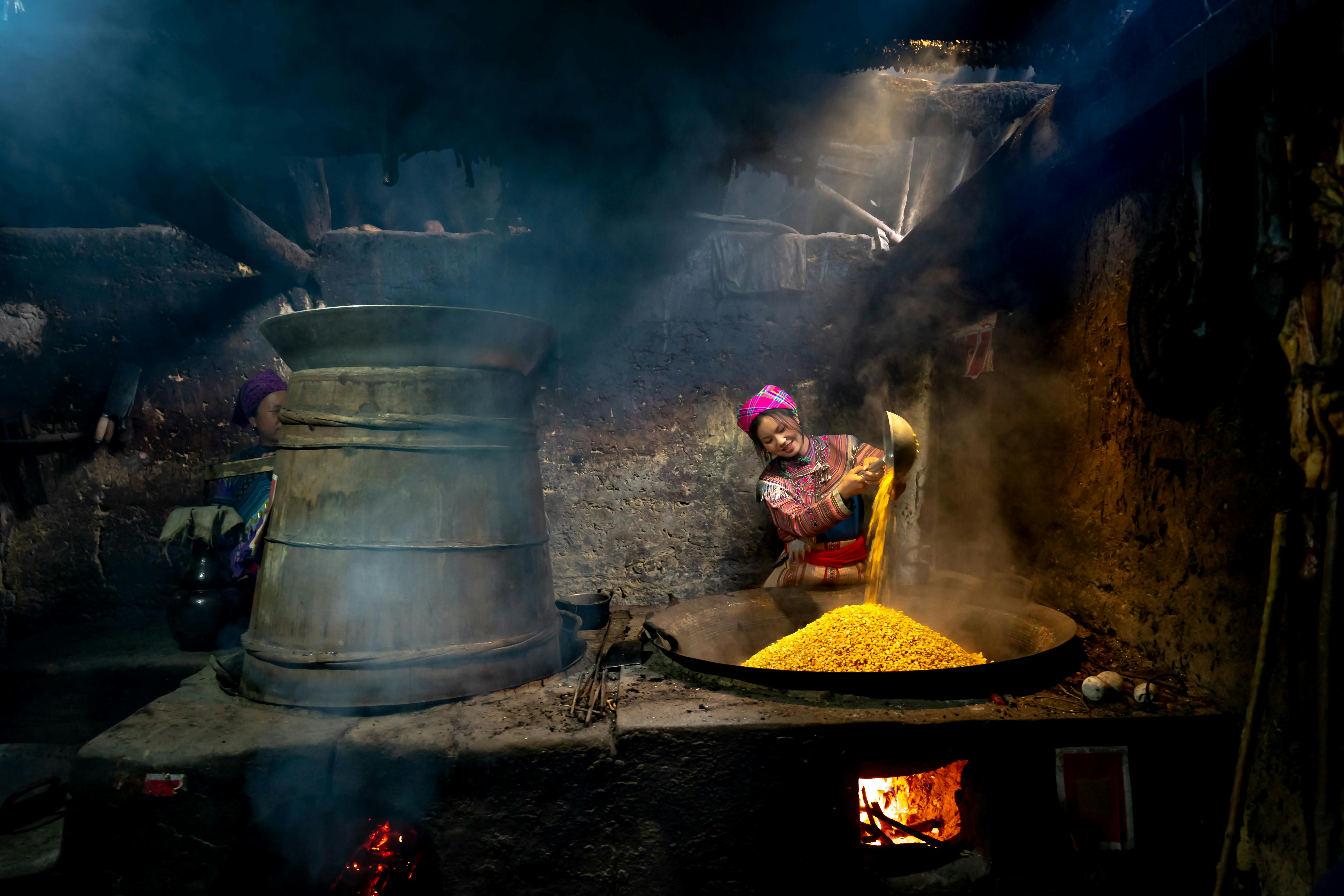 Woman Cooking on Fire in Wooden Shack · Free Stock Photo