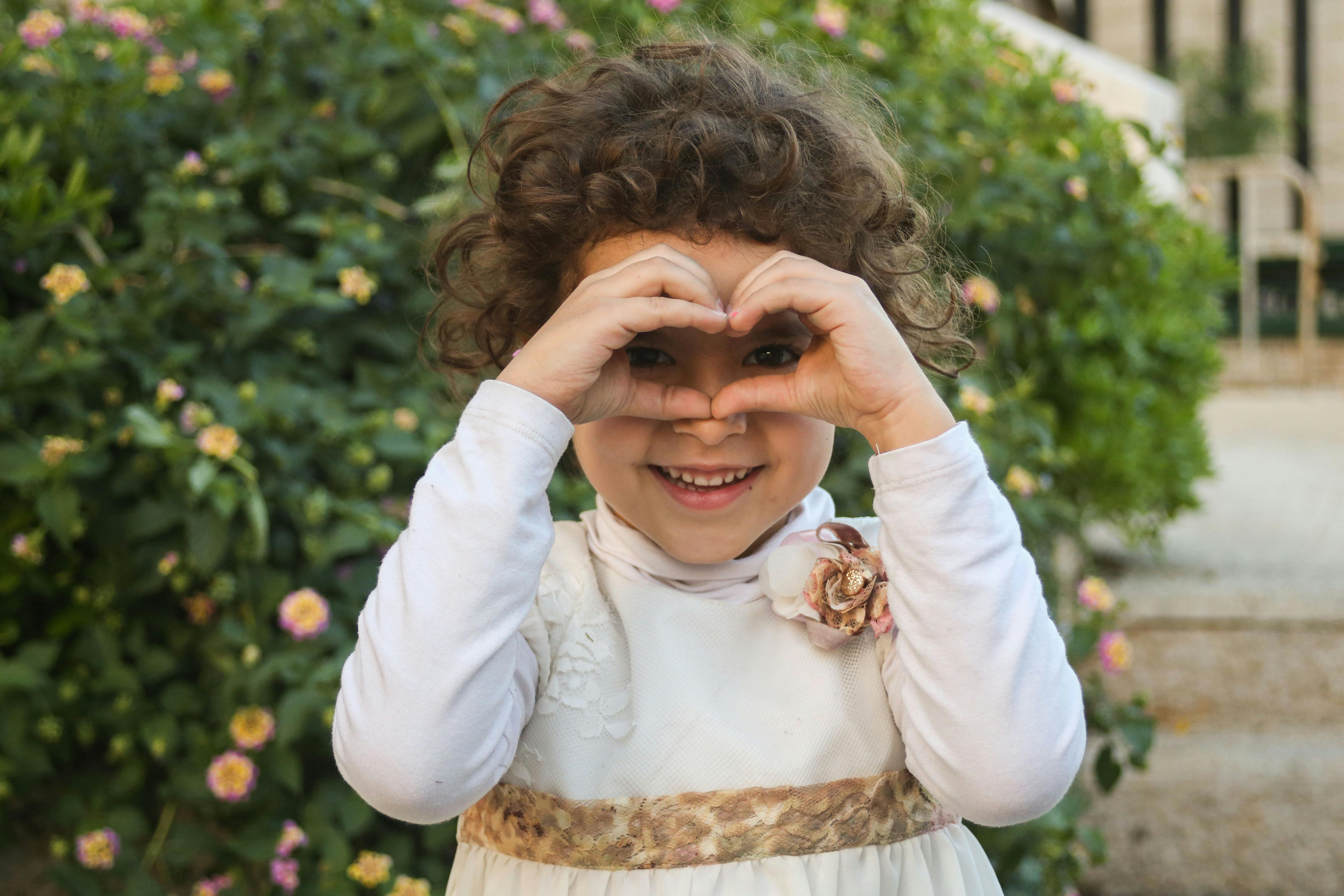 Photo of a Girl Looking Through a Heart Shape · Free Stock Photo