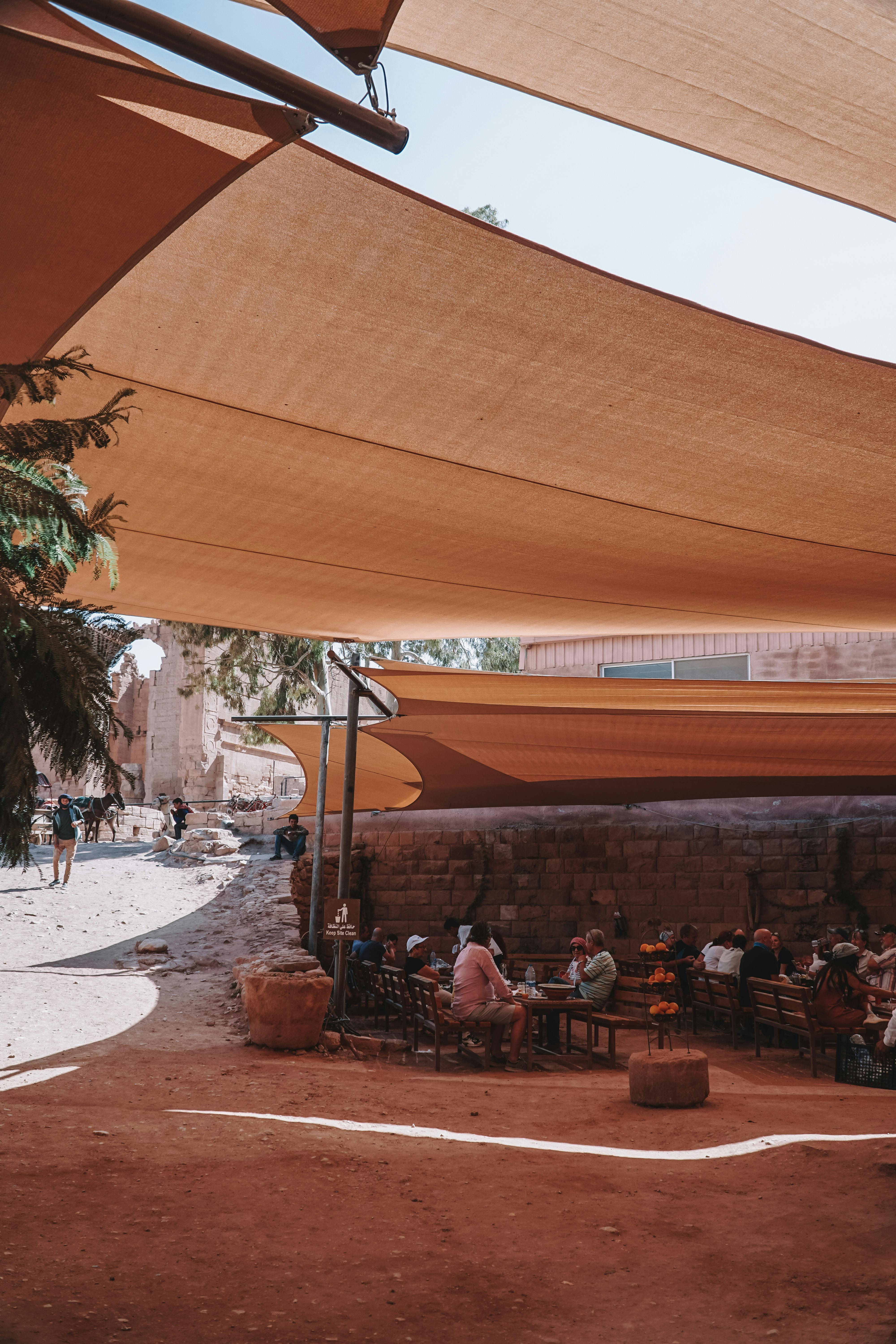 People Sitting in Shade under Linen Sheets · Free Stock Photo