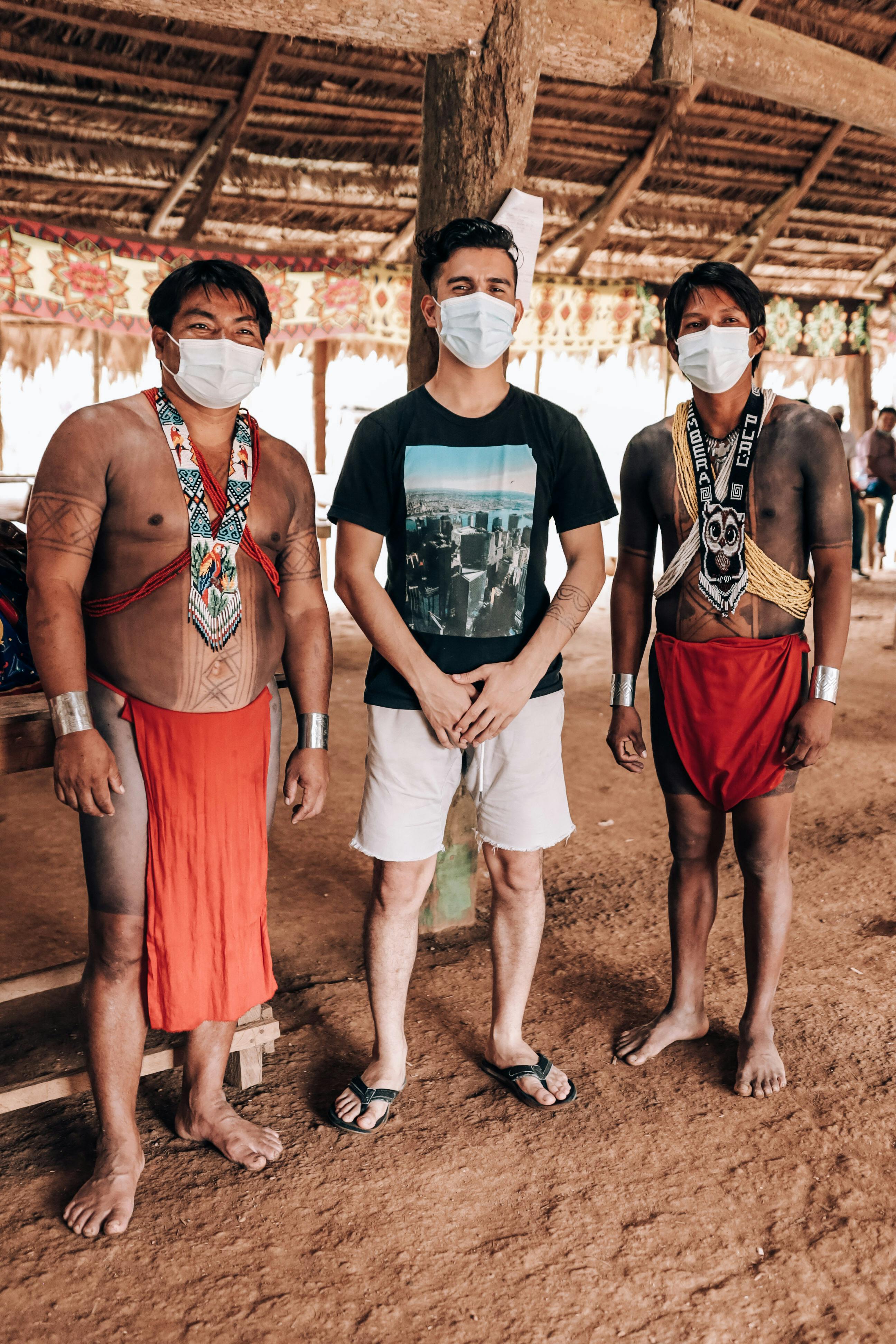 Portrait of Tourist with Men in Tribal Outfits · Free Stock Photo