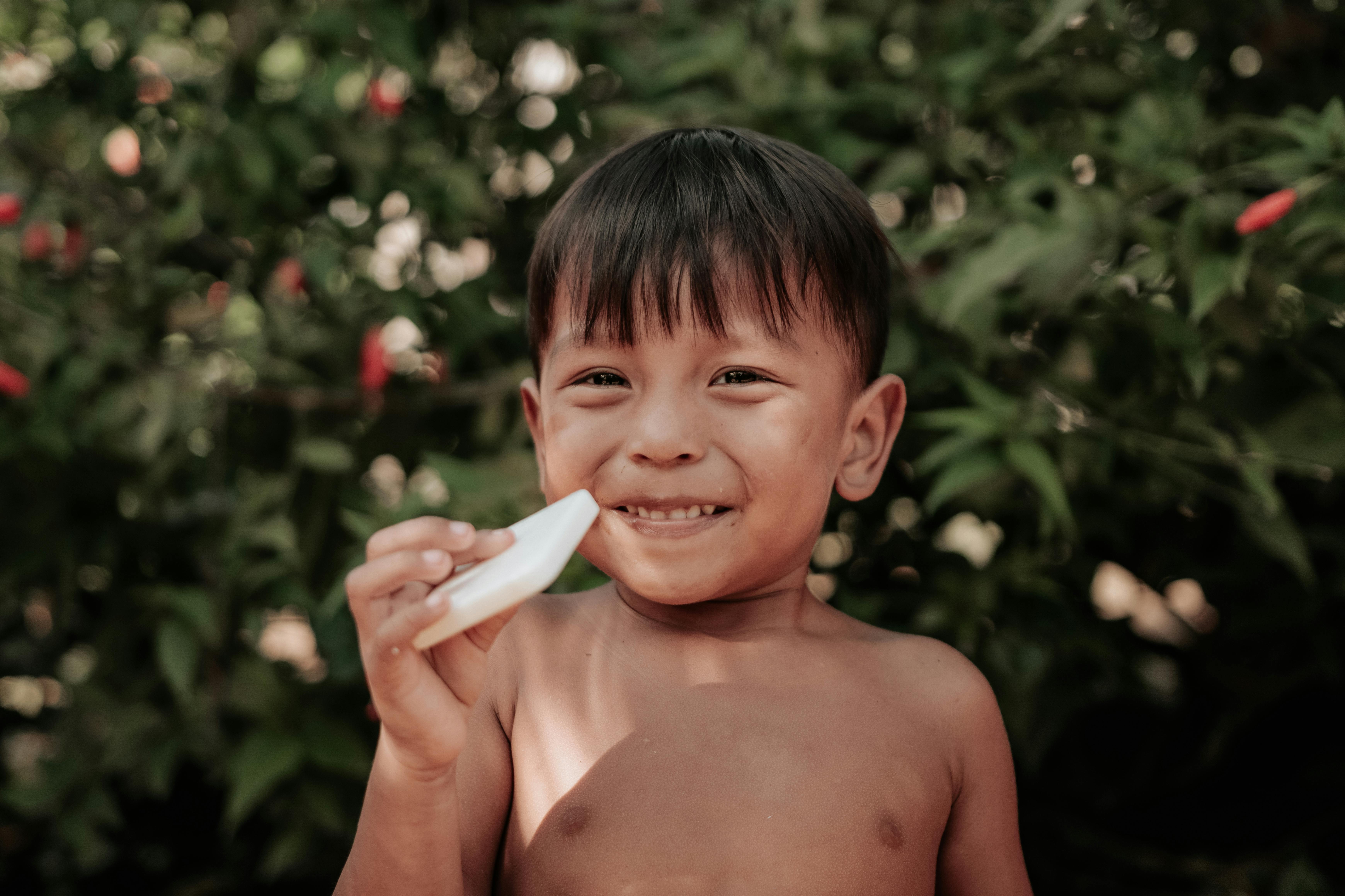 A Shirtless Kid Holding a Soap Bar · Free Stock Photo