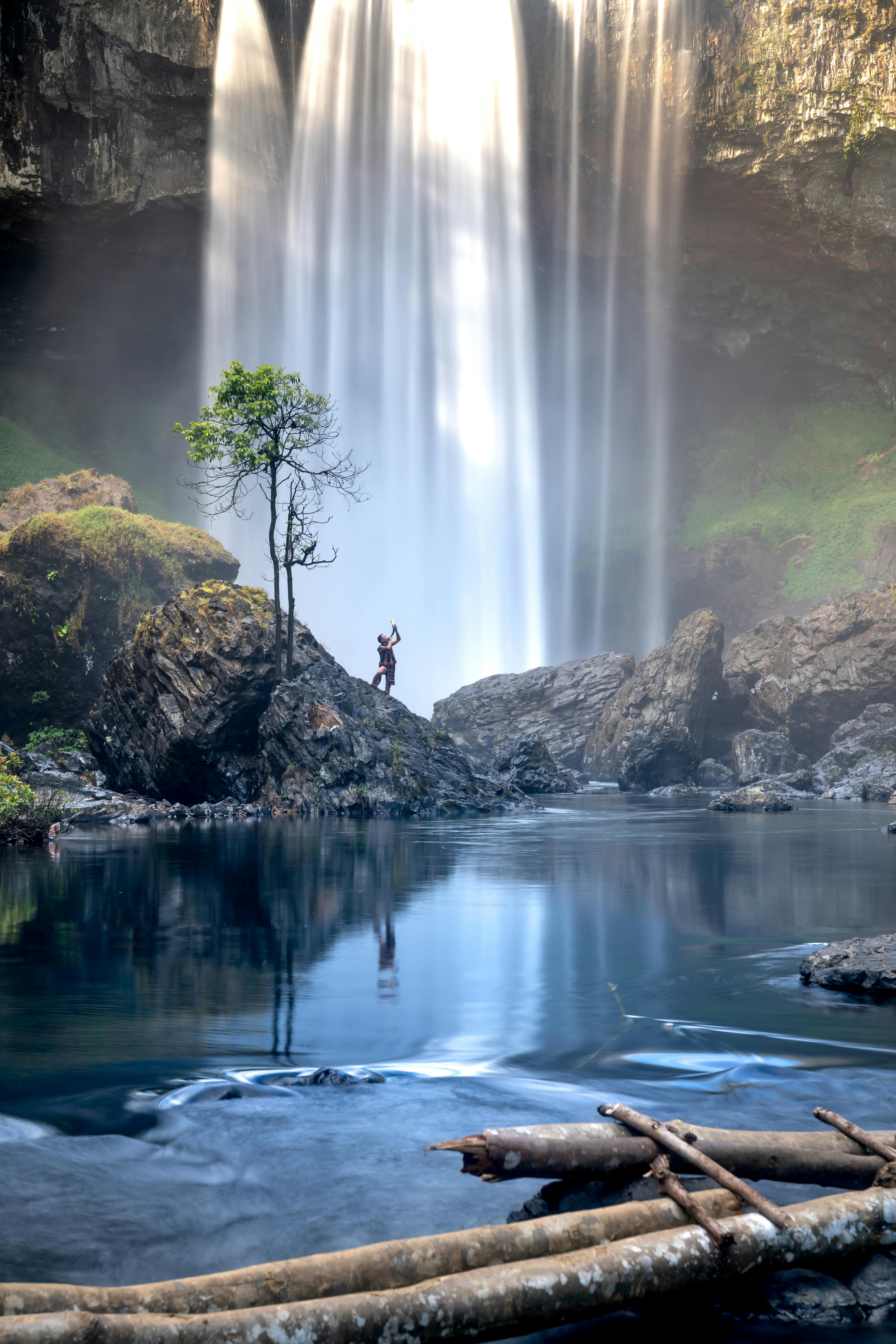Person Standing on Rock near Waterfall · Free Stock Photo