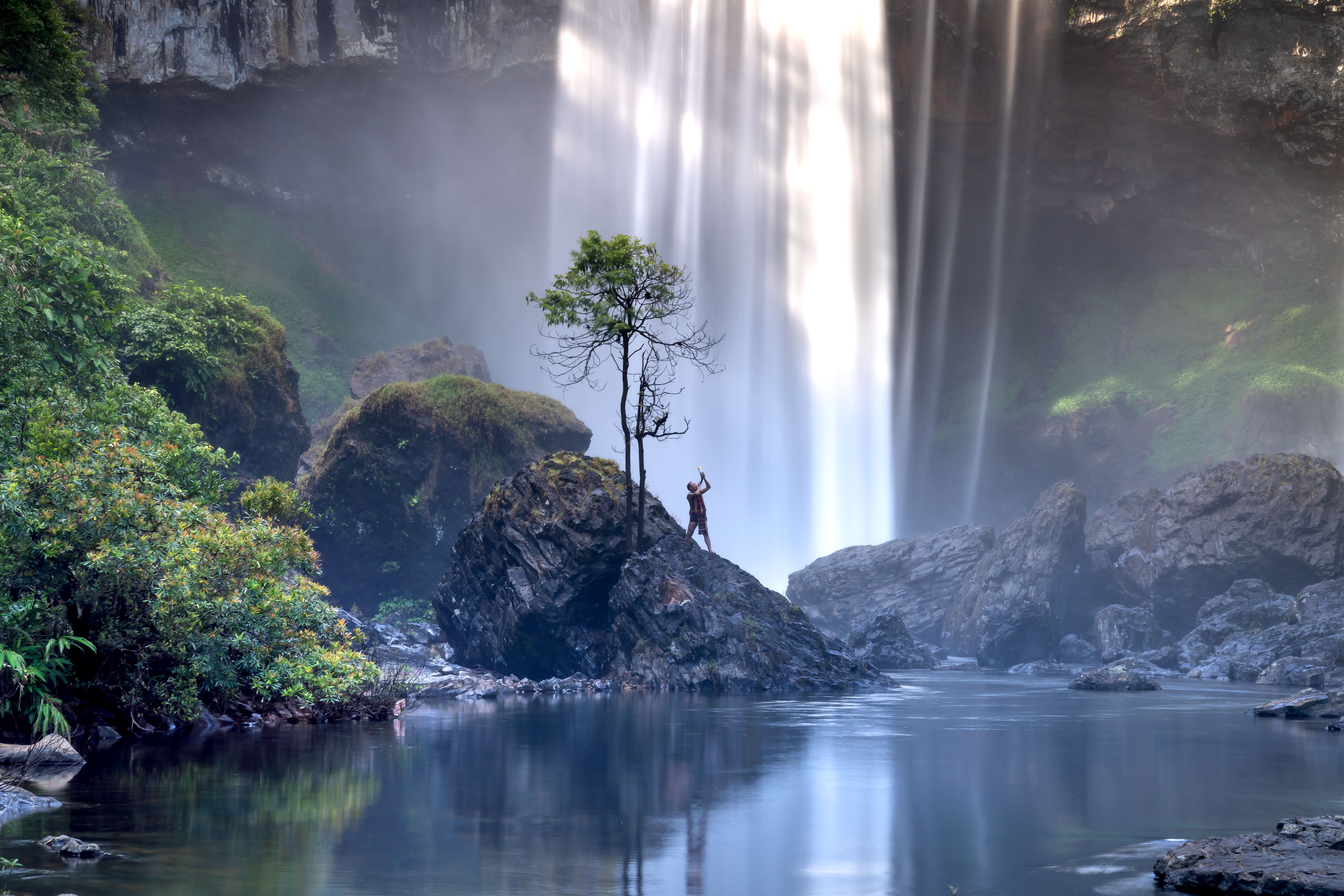 Person Standing on Rock Near Waterfalls · Free Stock Photo