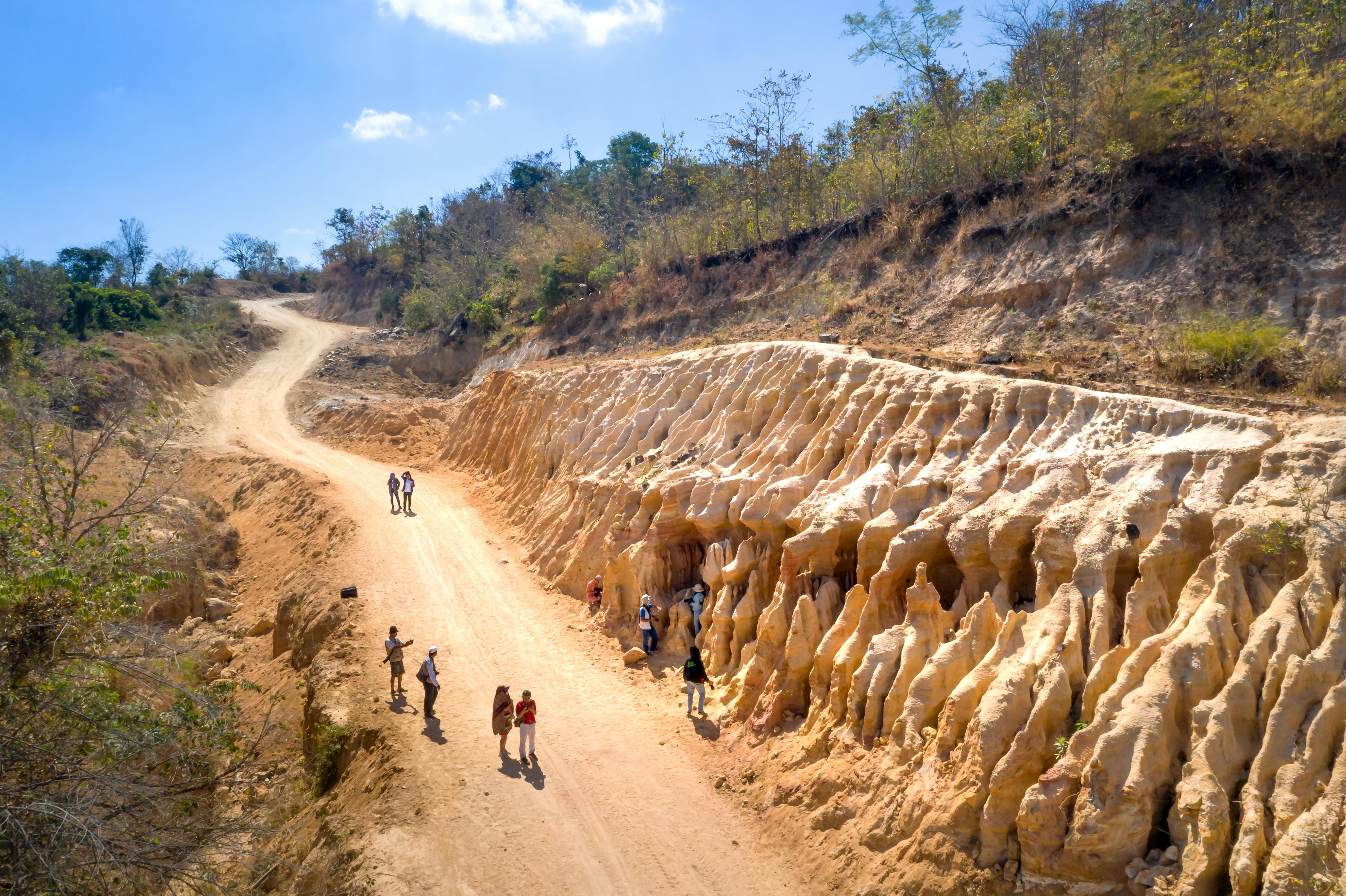 People Hiking past Rock Formations · Free Stock Photo