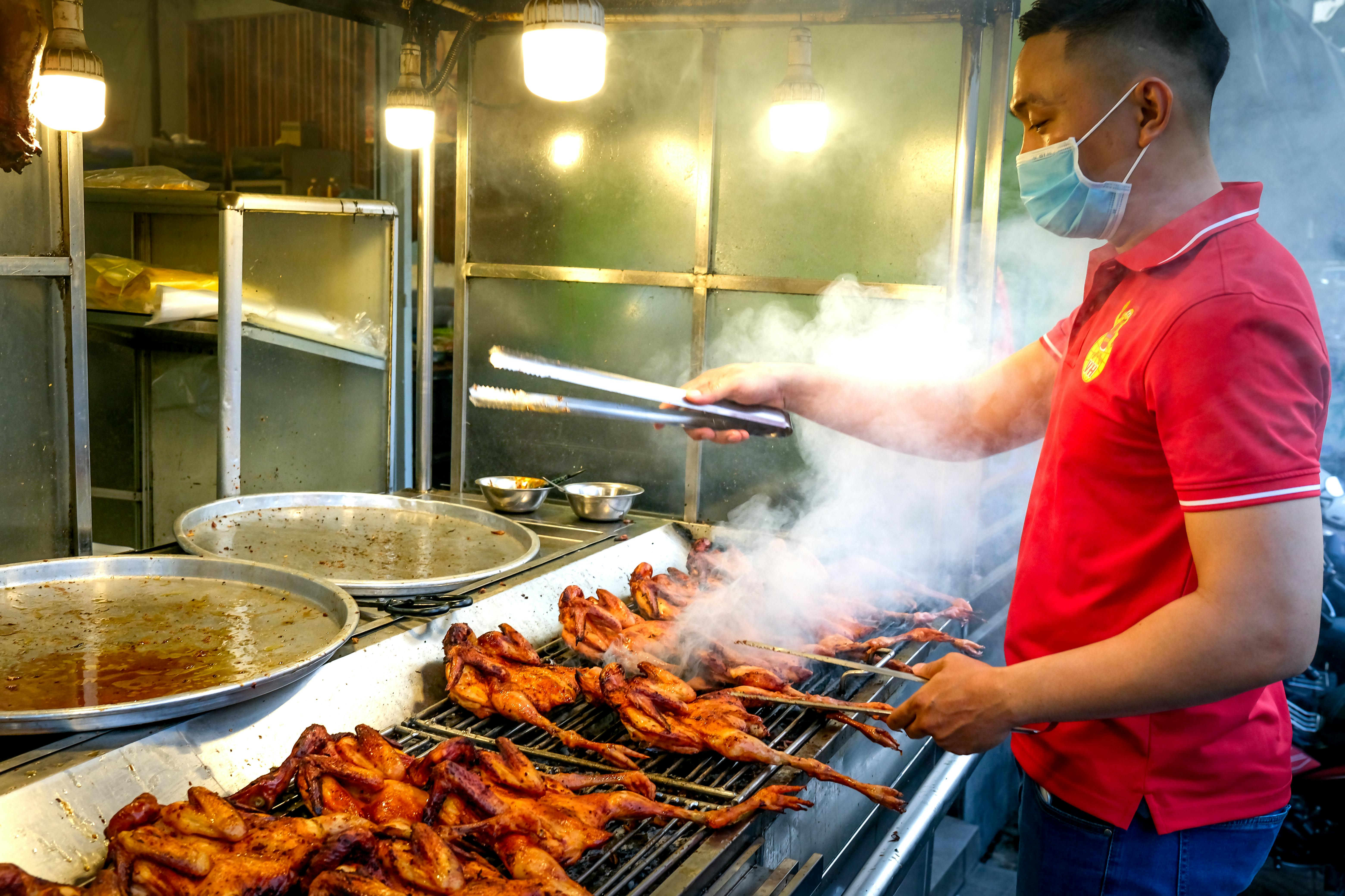 A Man in a Red Polo Shirt Grilling Chicken · Free Stock Photo