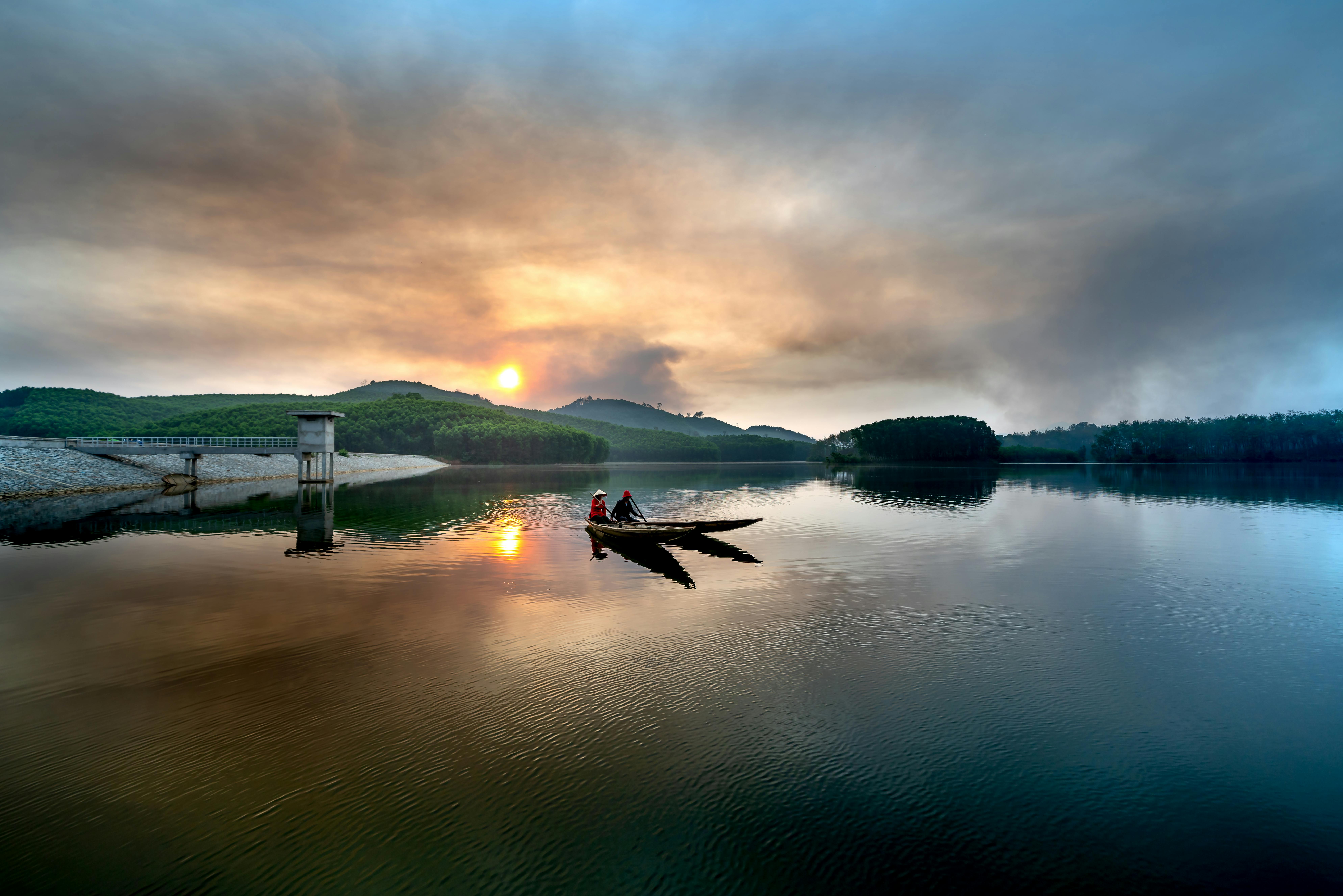Two People Rowing across a Lake at Sunset · Free Stock Photo