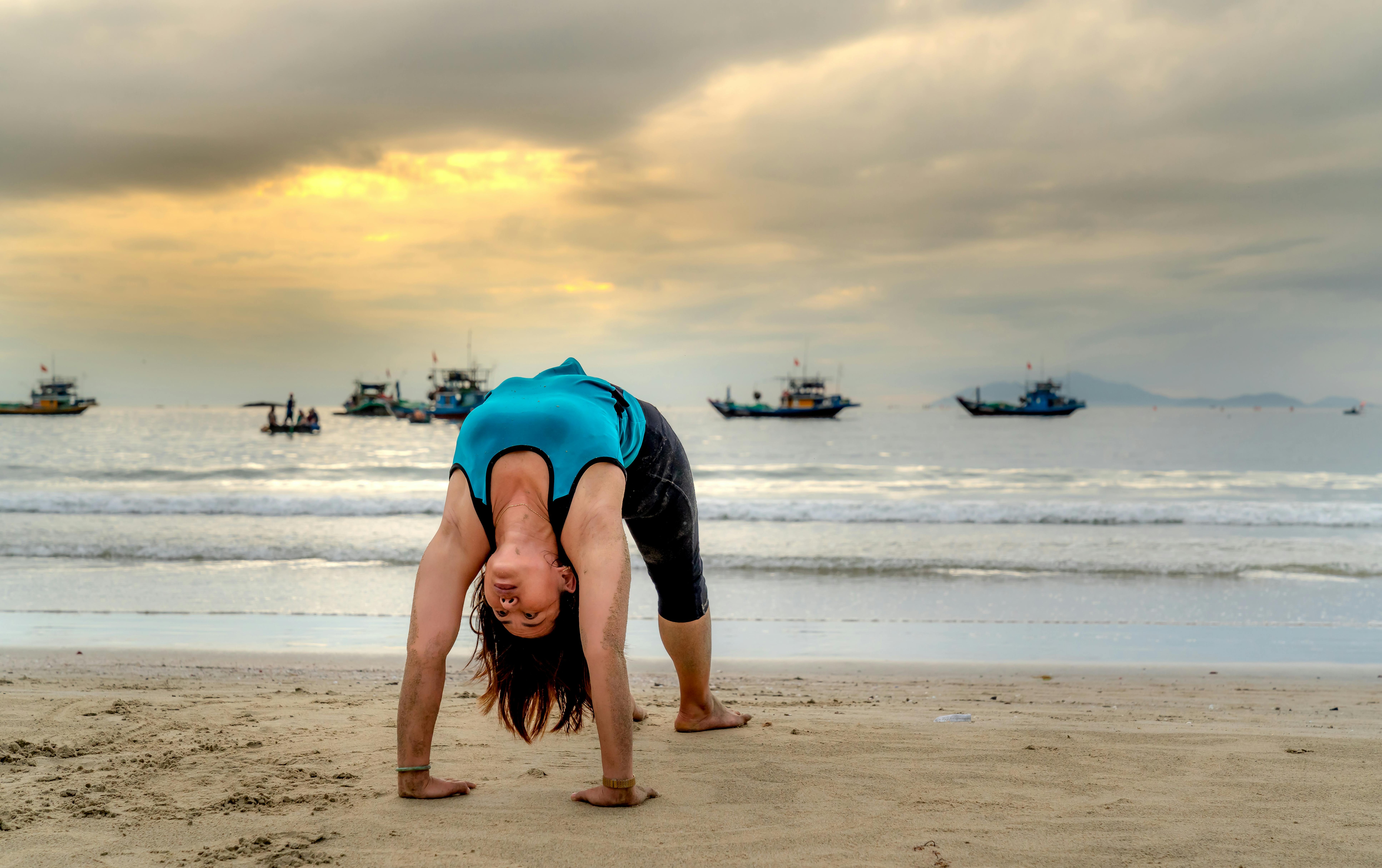 Woman in Blue Tank Top Doing Bending Exercise · Free Stock Photo