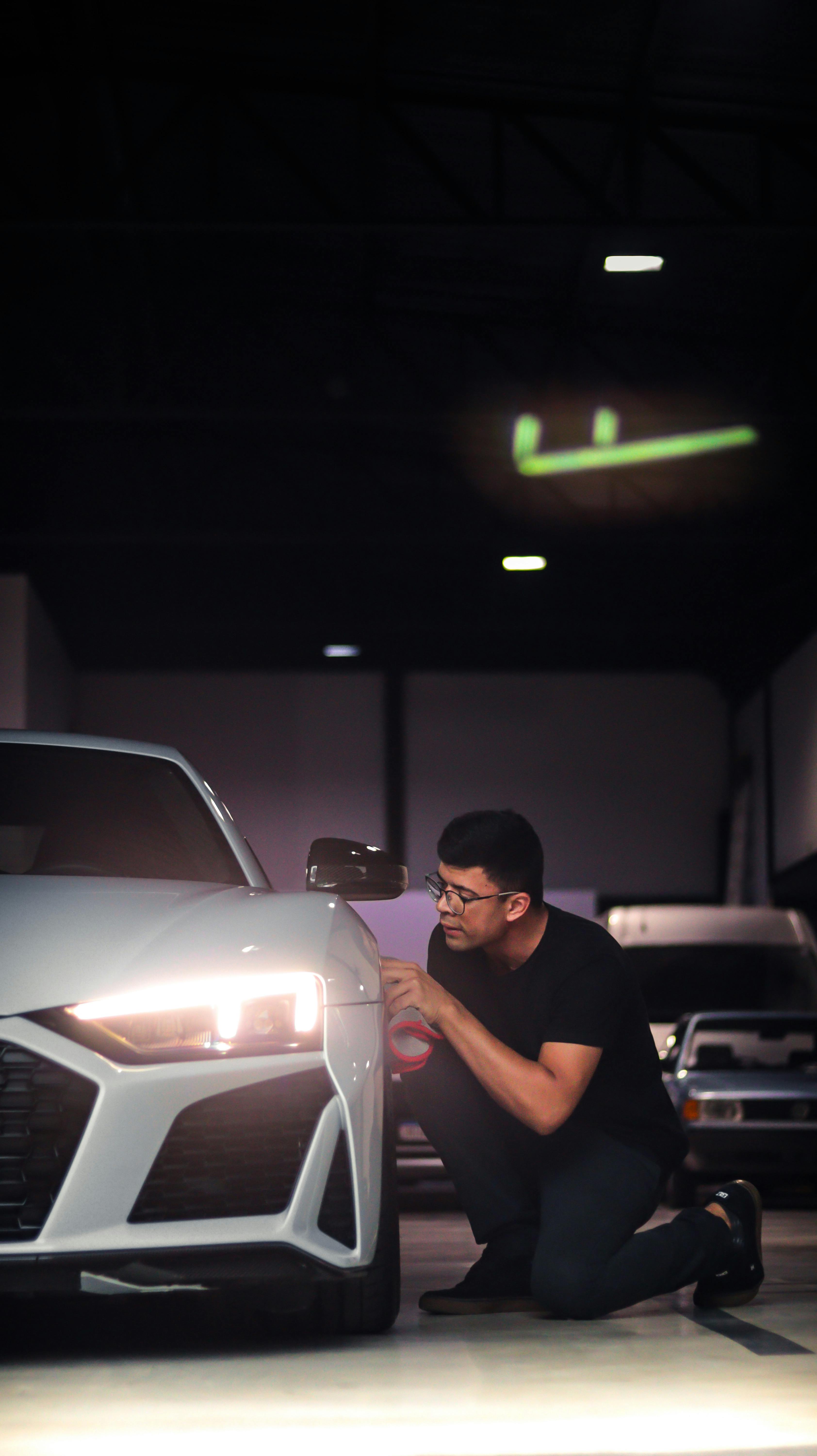 A Man Wrapping a Car Hood · Free Stock Photo