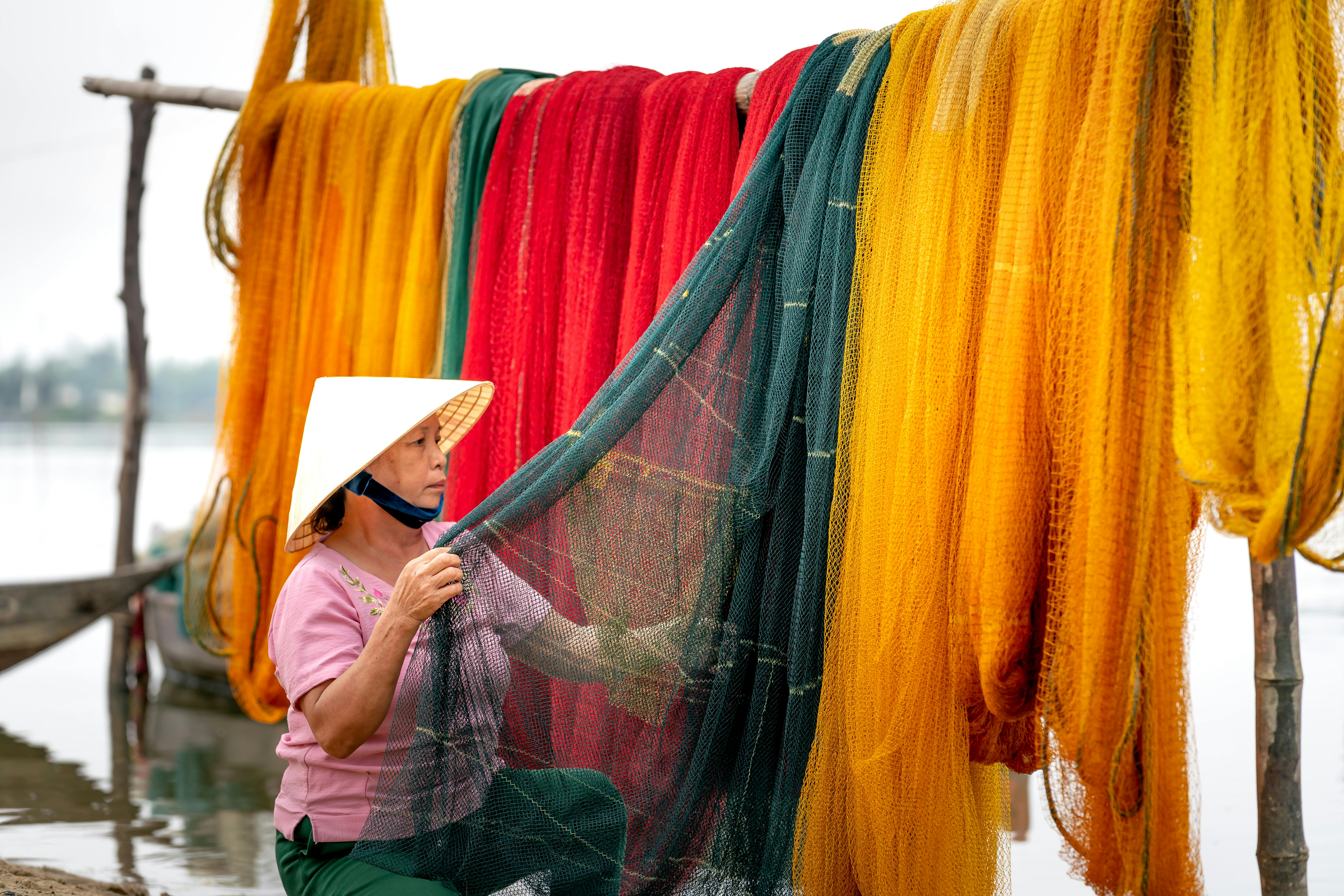 Woman Hanging up Colorful Fishing Nets · Free Stock Photo