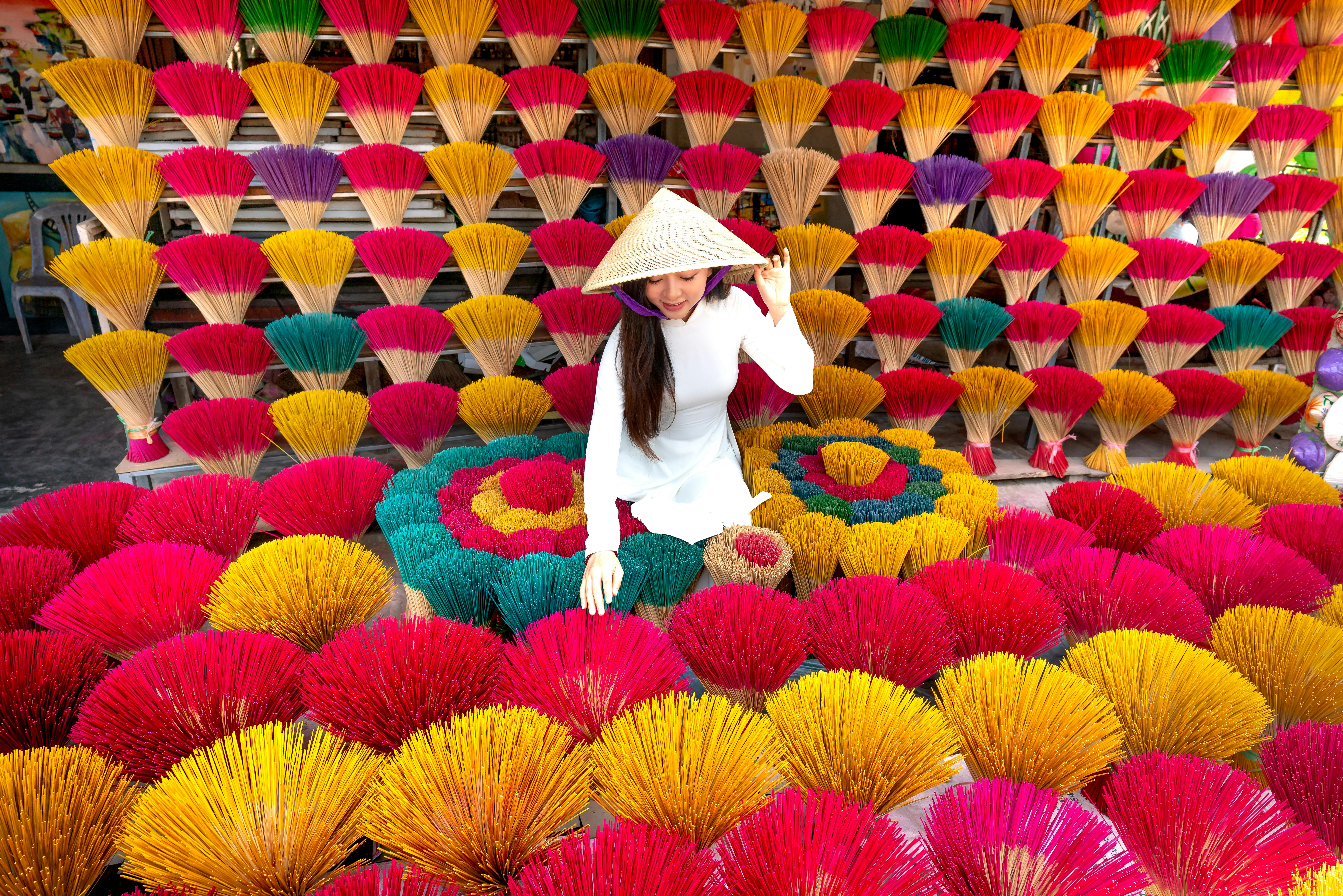 Woman in White Dress Touching Colorful Incense Sticks · Free Stock Photo