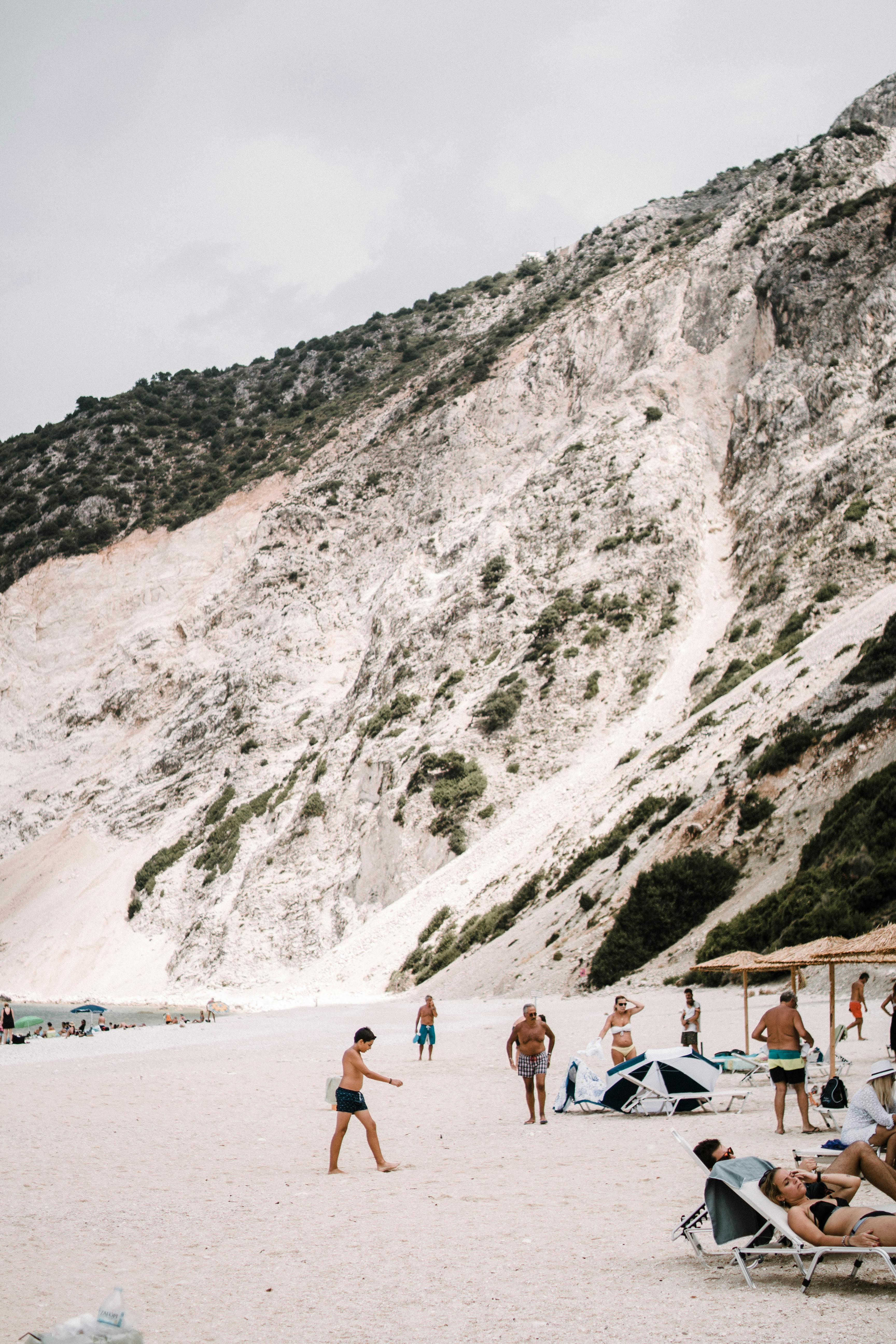 Menschen Am Strand In Der Nähe Von Berg · Kostenloses Stock Foto