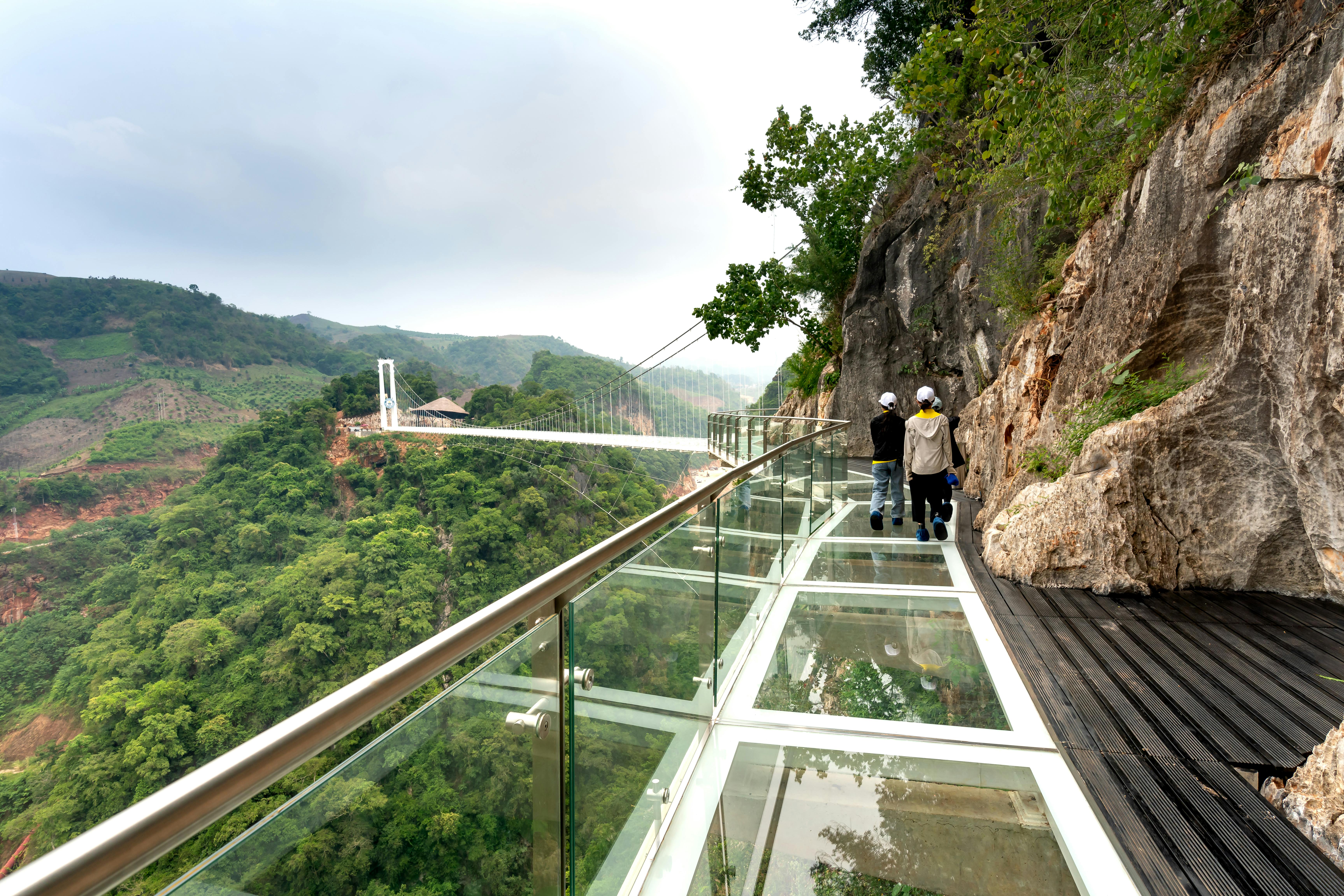 Men Walking on a Glass Bridge by a Cliff · Free Stock Photo
